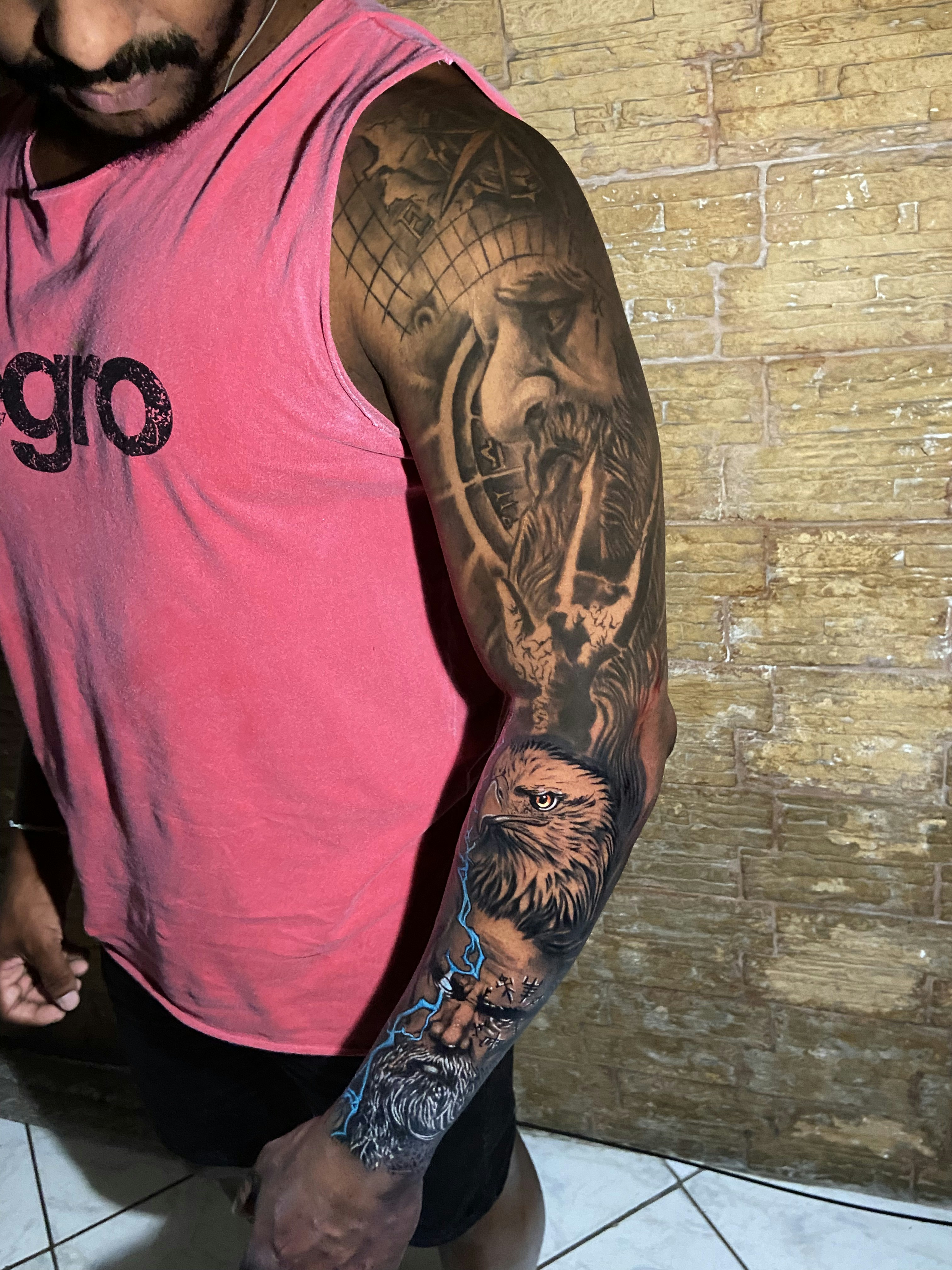 Brick-Walled Ink: A tattooed forearm in a pink tee