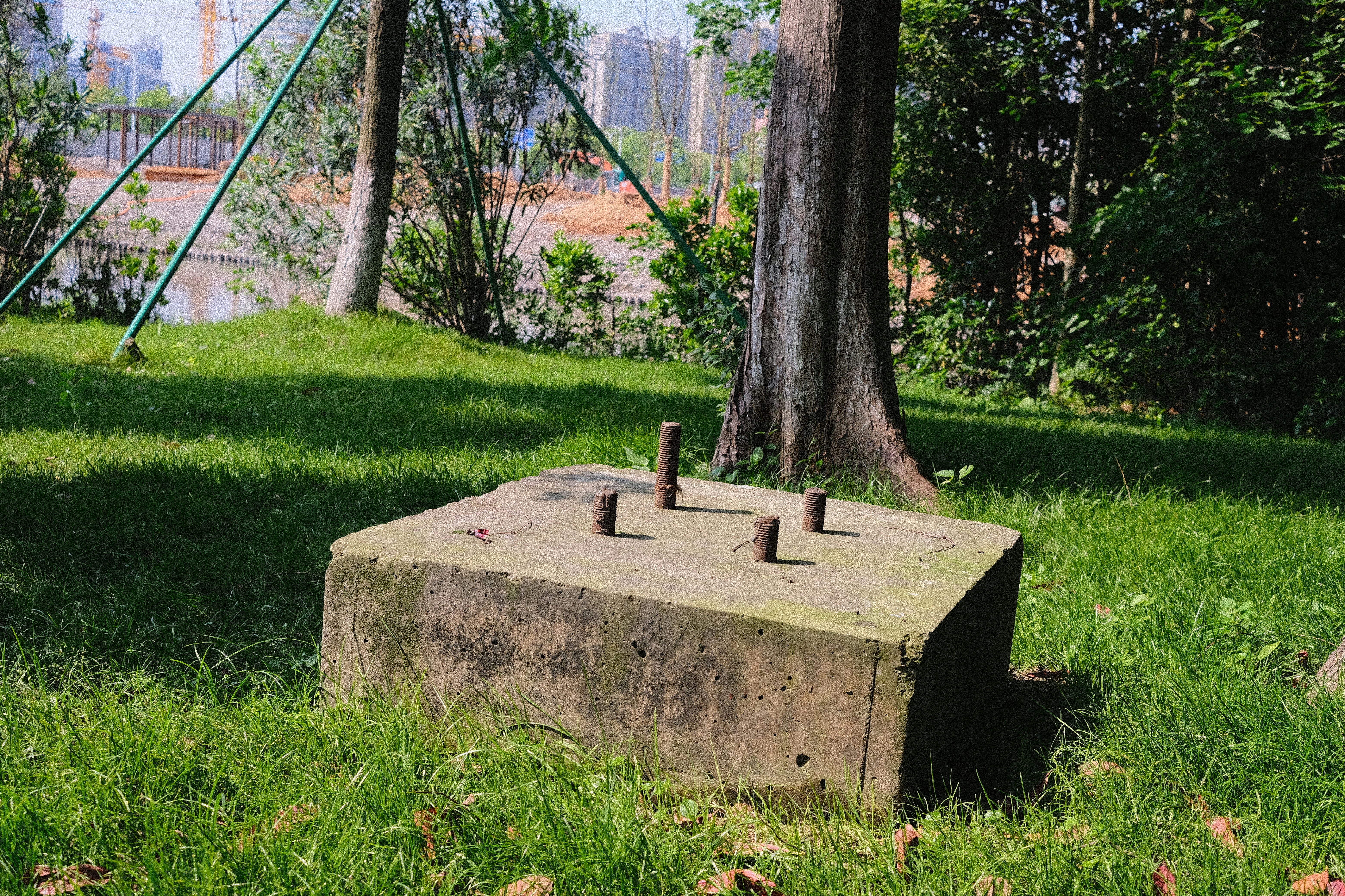 Quiet Concrete Altar: Bolts Rising from a Park Block