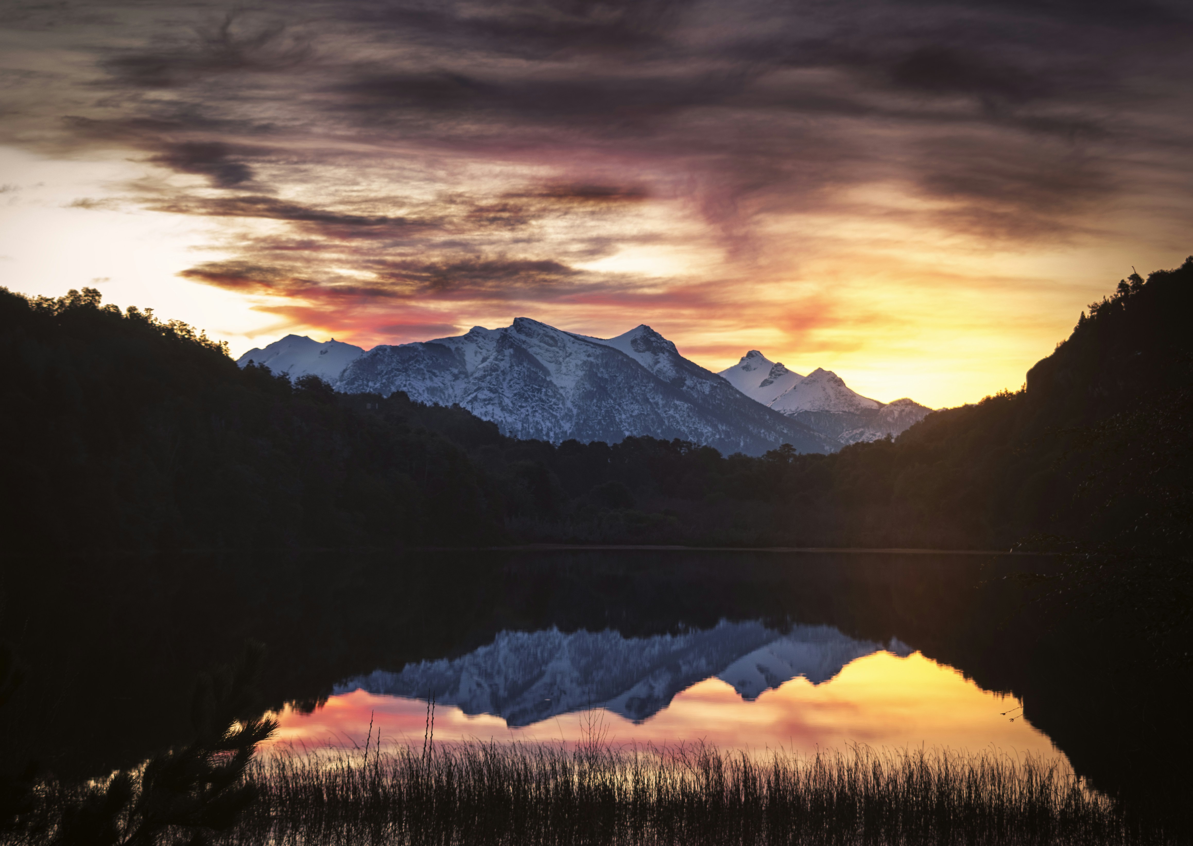 Bariloche | a lake with mountains in the background at sunset