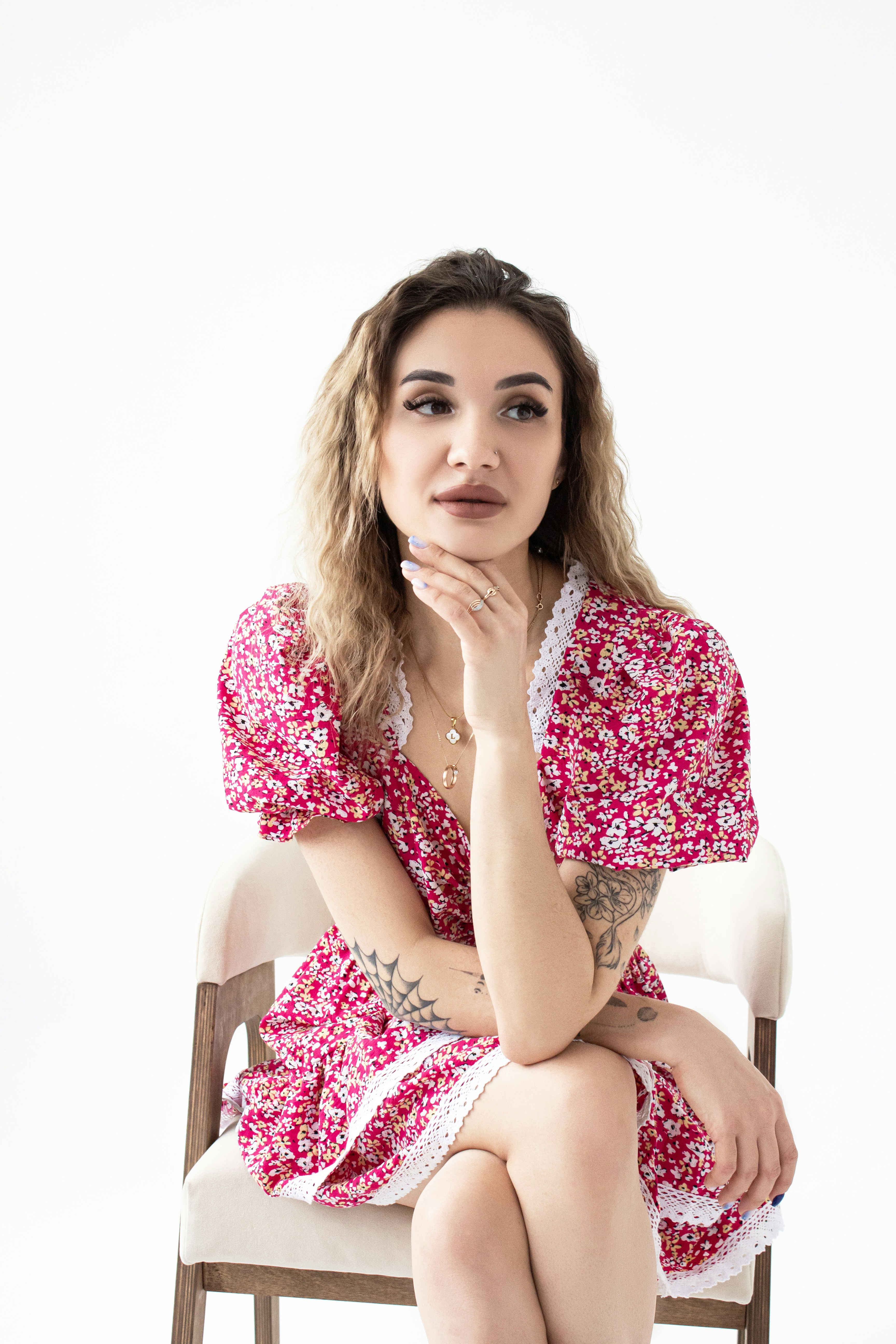Contemplative Portrait: Tattooed Woman in a Pink Floral Dress