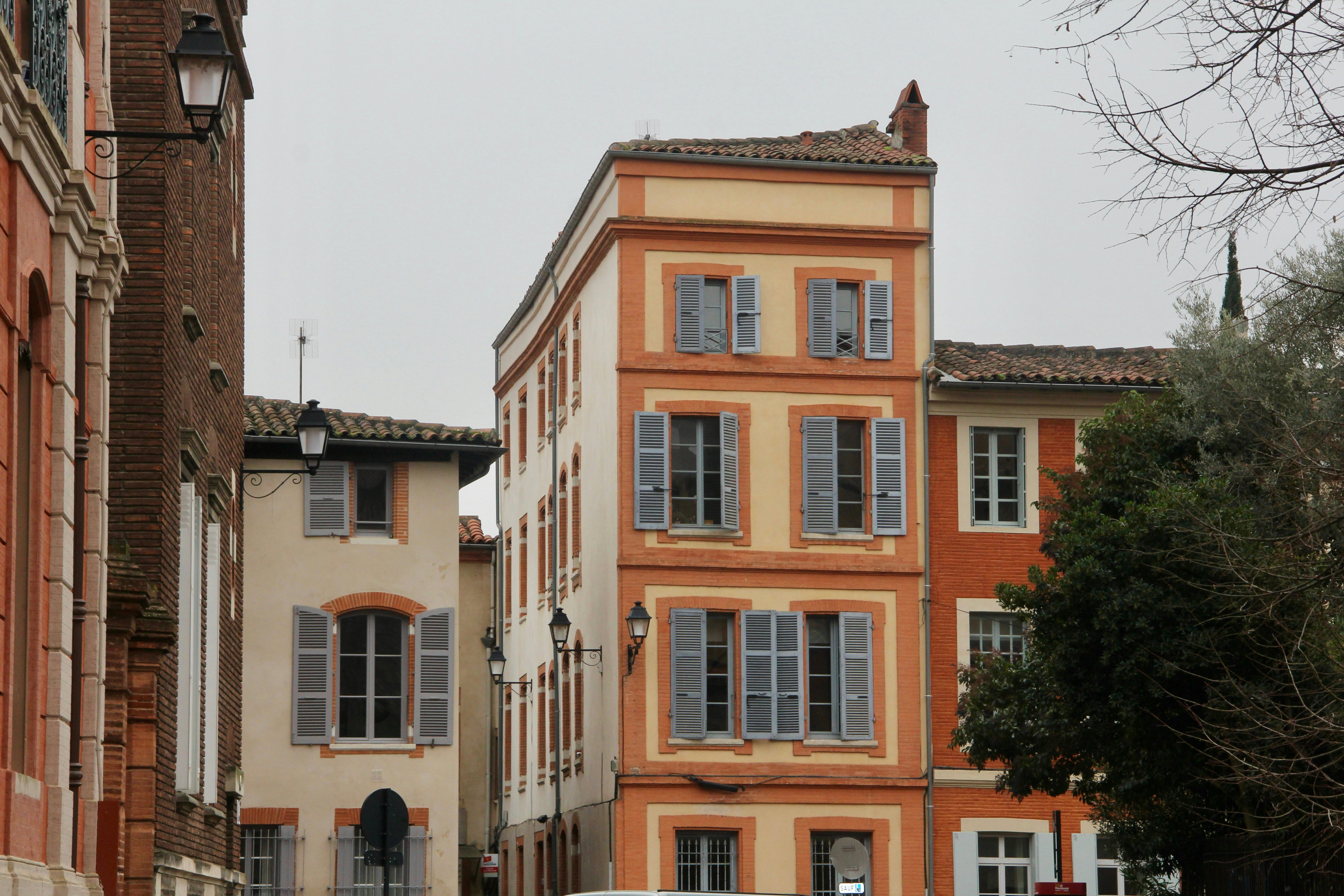 Sunlit Facades and Shuttered Windows on a Narrow European Street