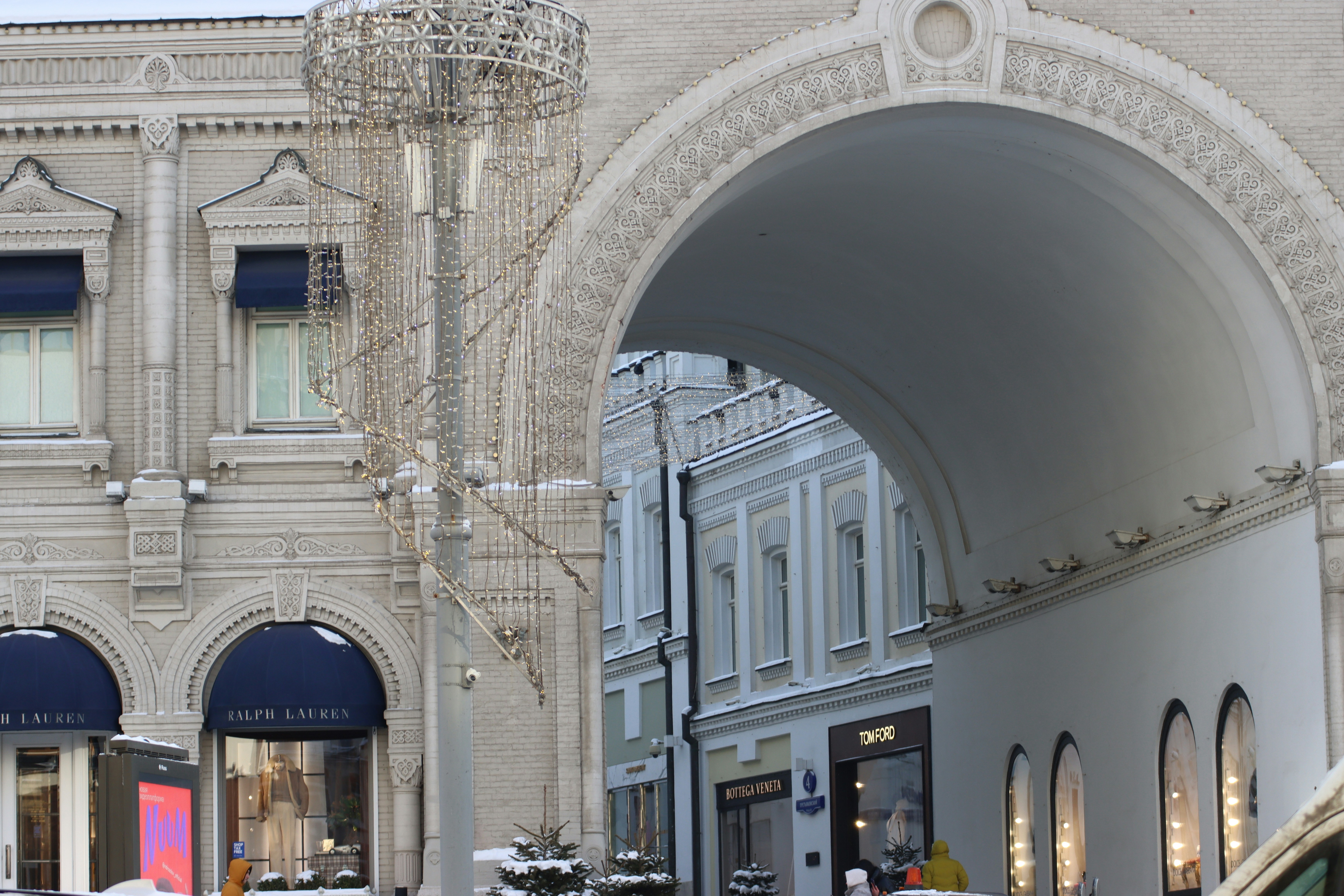 Through the Grand Arch: Snow-Dusted Arcade Framing a Luminous European Street
