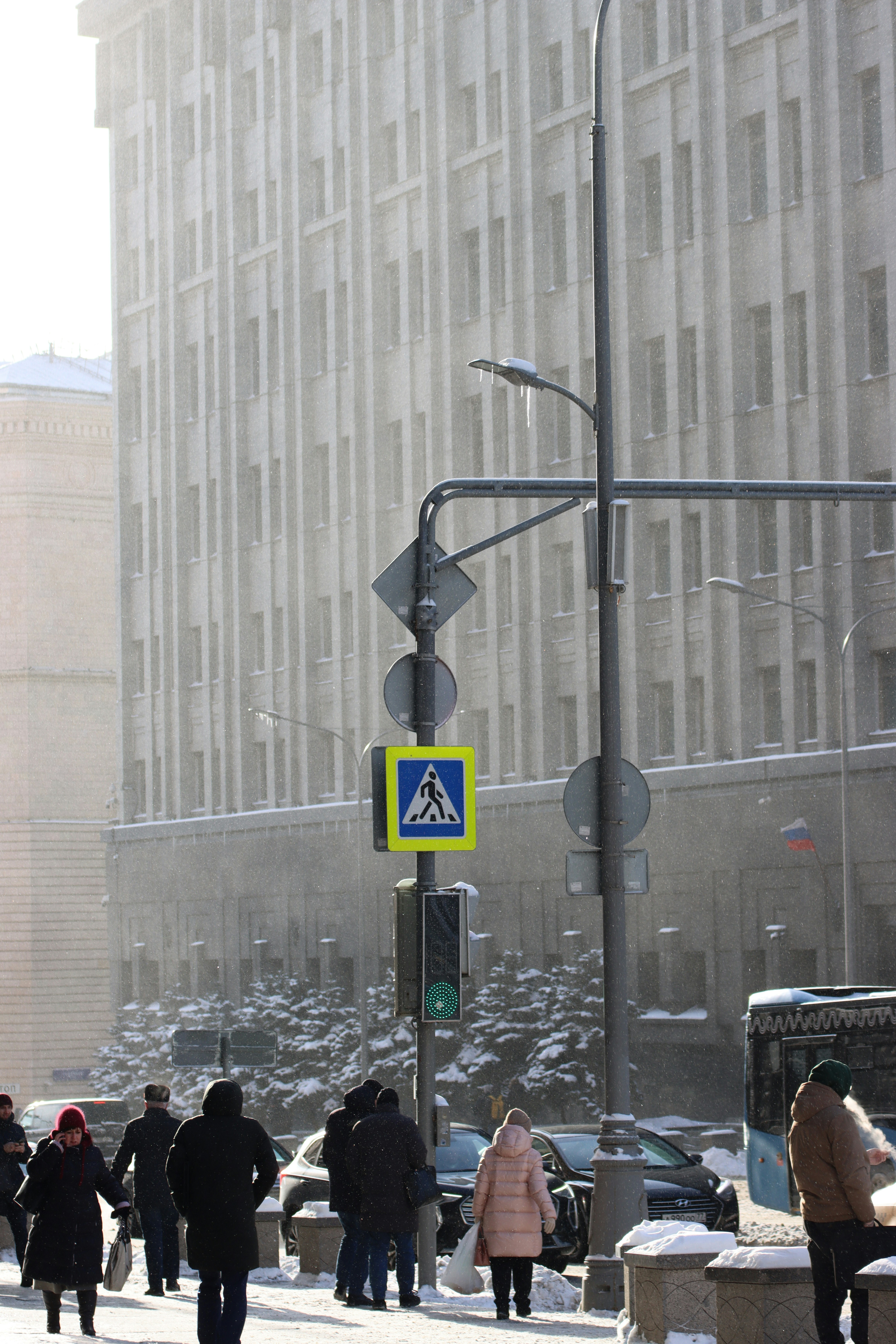 Winter Crosswalk Sentinel: Pedestrian Sign Amid Snow-Dusted City