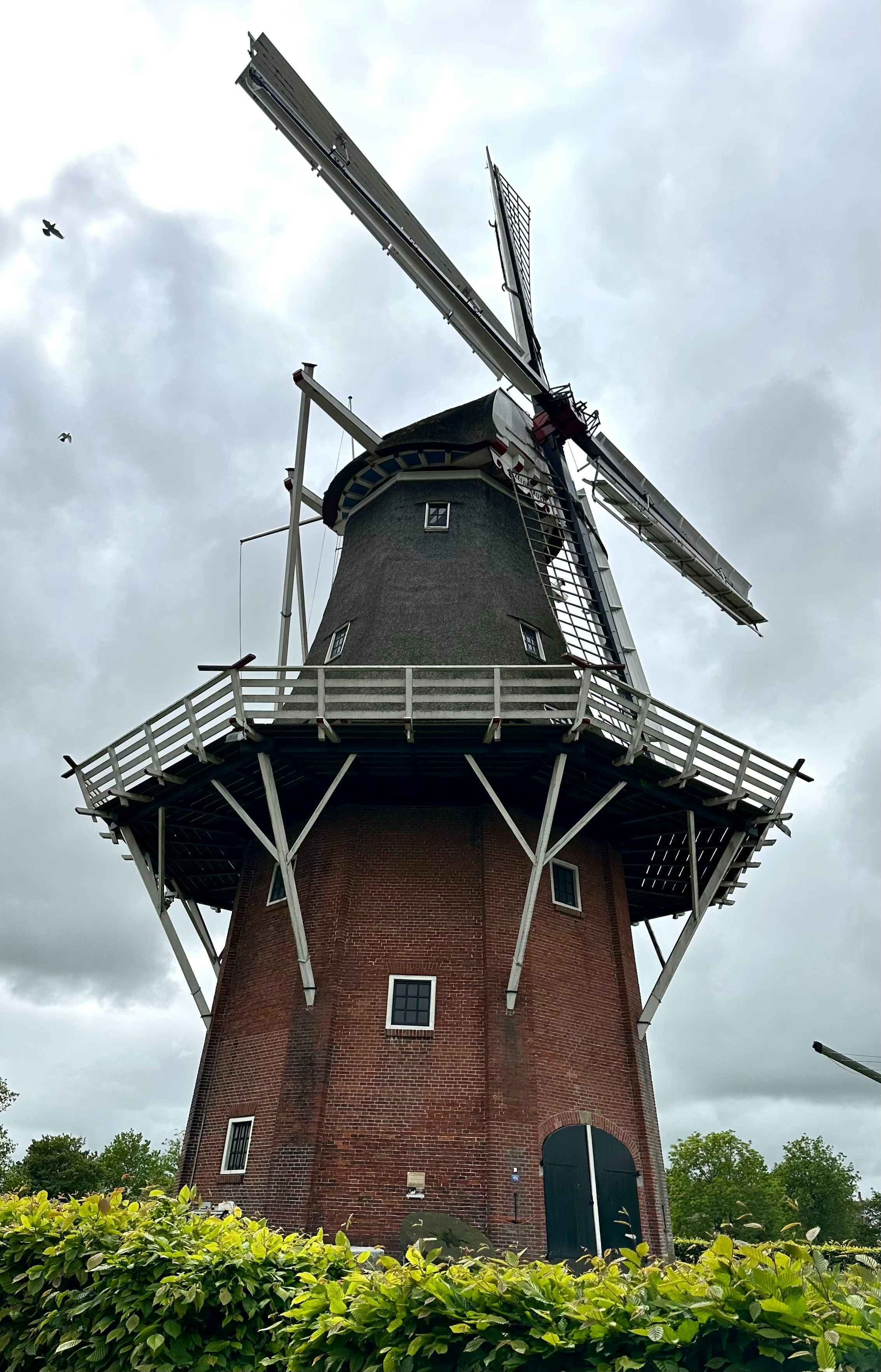 Sails over Brick: A Windmill Standing Tall Under a Moody Sky