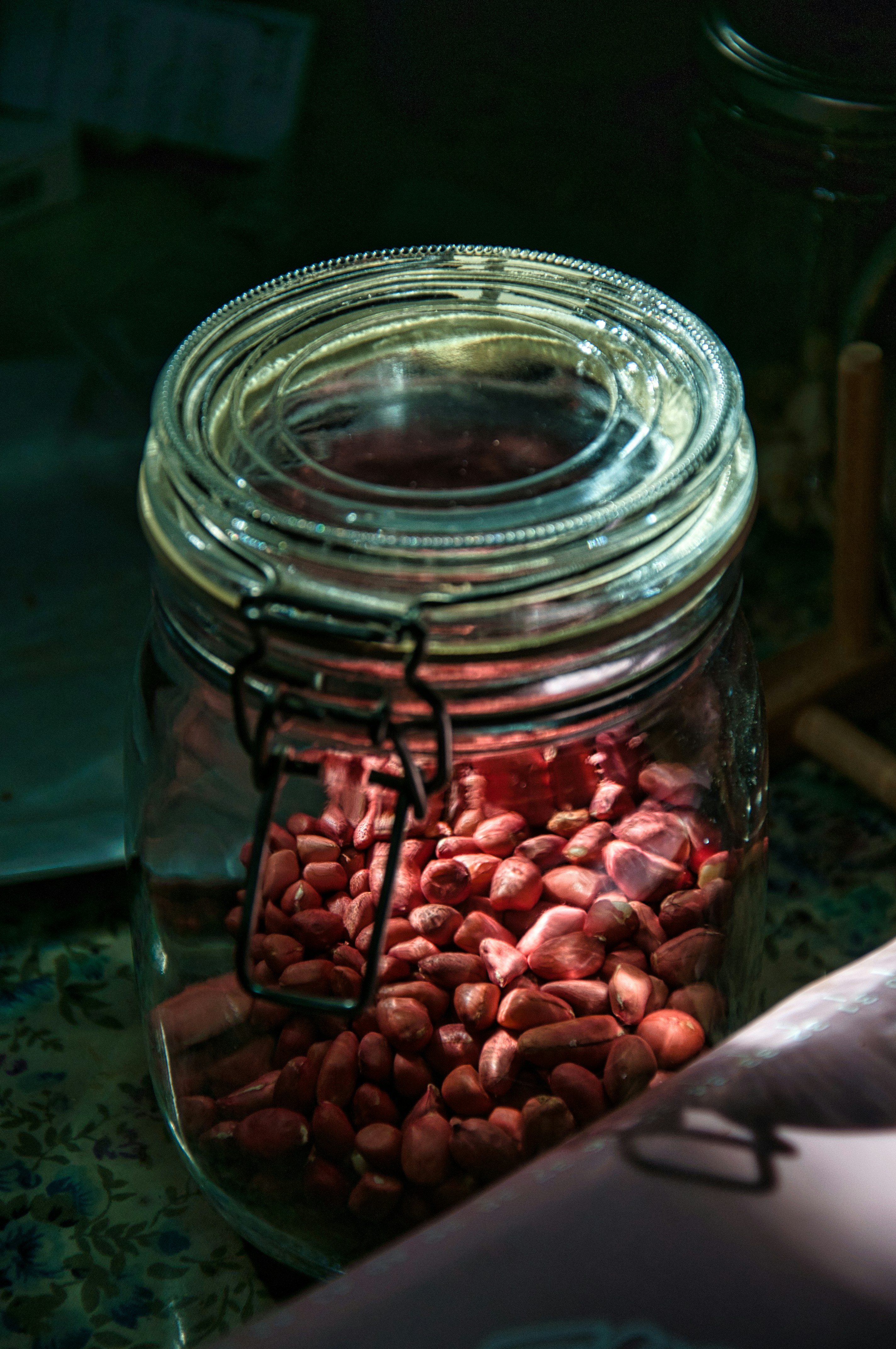 A jar filled with red rocks sitting on top of a table photo – Free Jar ...