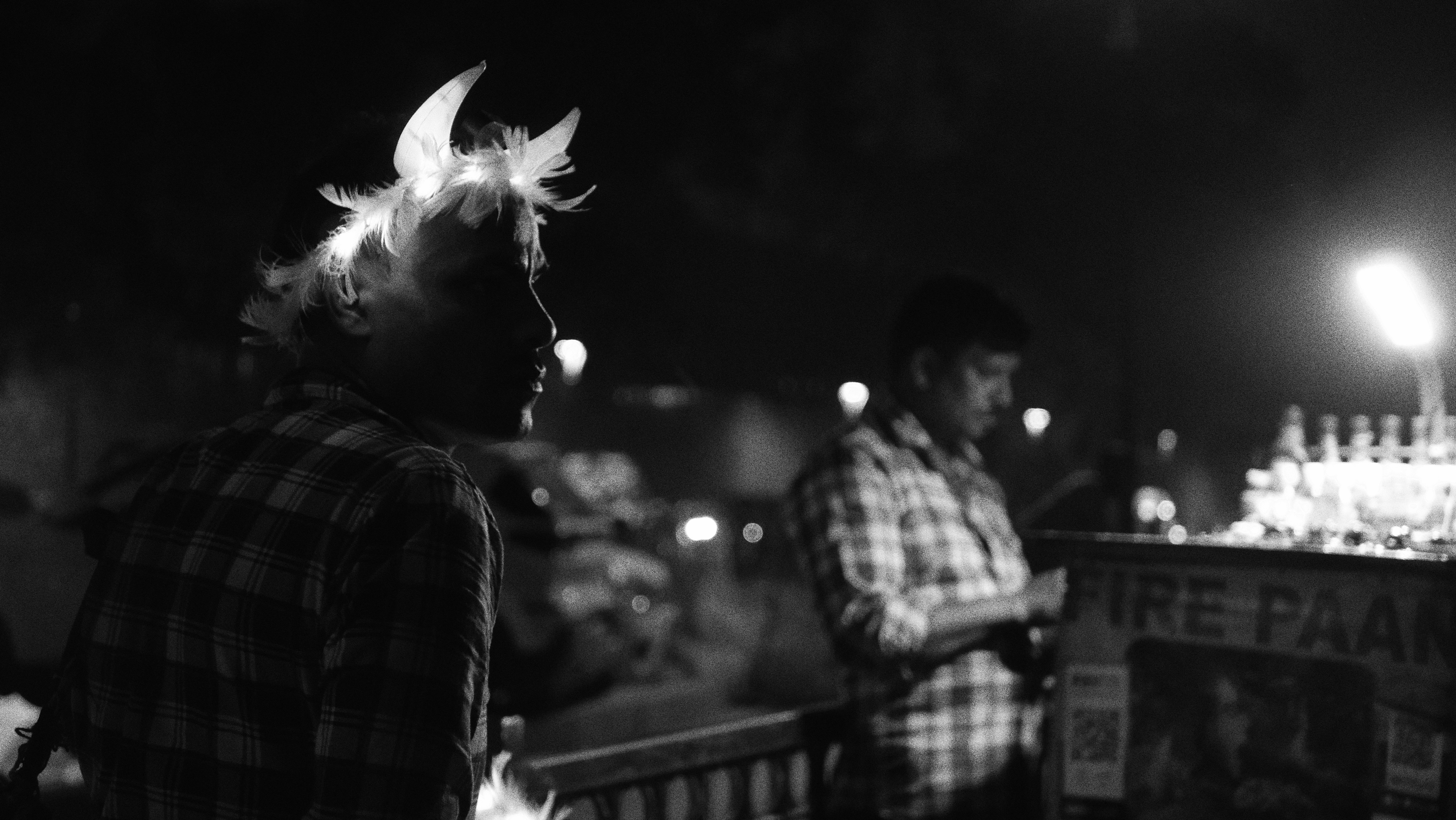 A man wearing a devil mask standing in front of a bar photo – Free ...