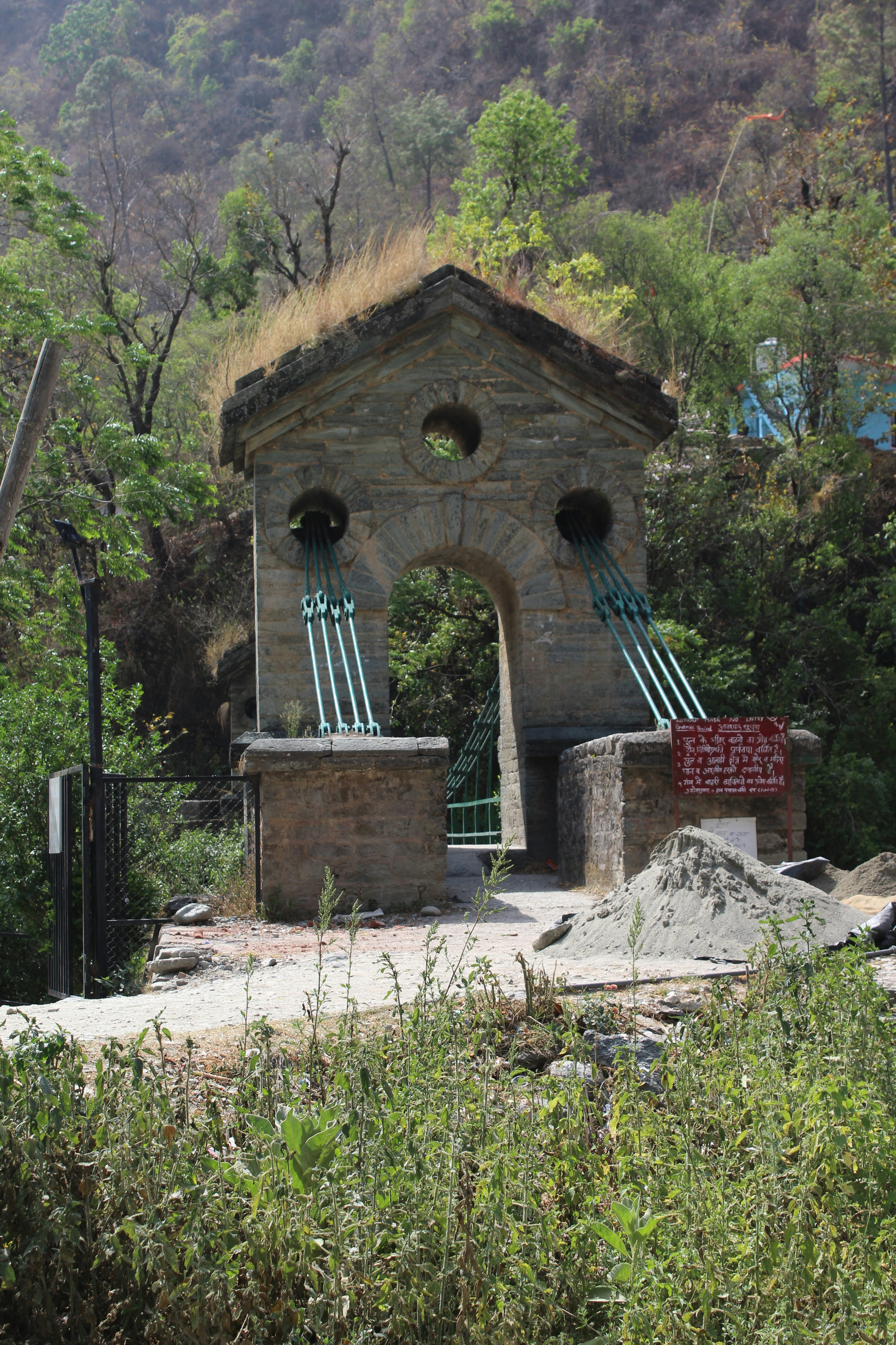Turquoise-Roped Gateway Amid Pines and Mountain Ruin
