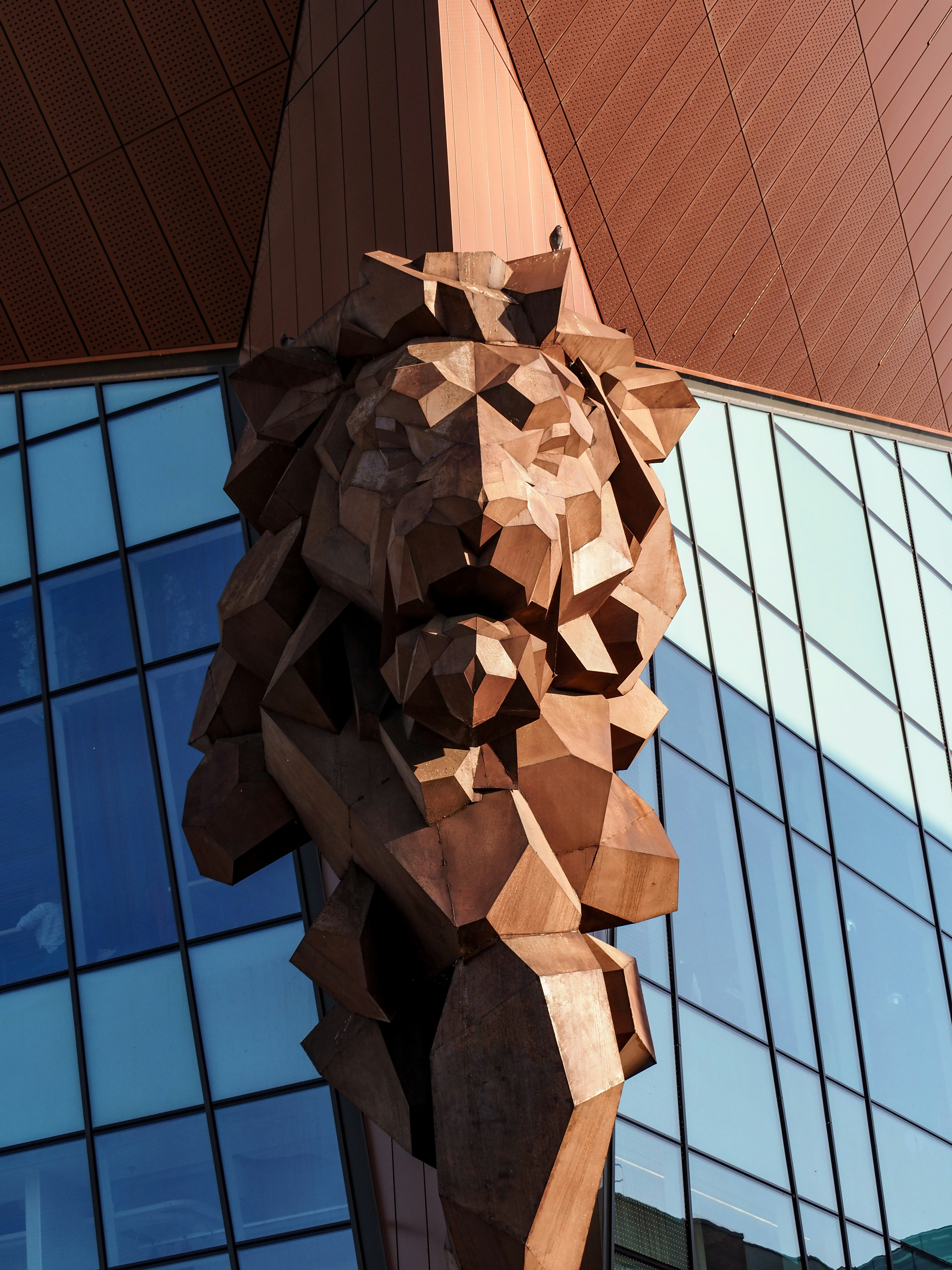 Geometric Guardian: a sculptural titan towering beside glass and brick