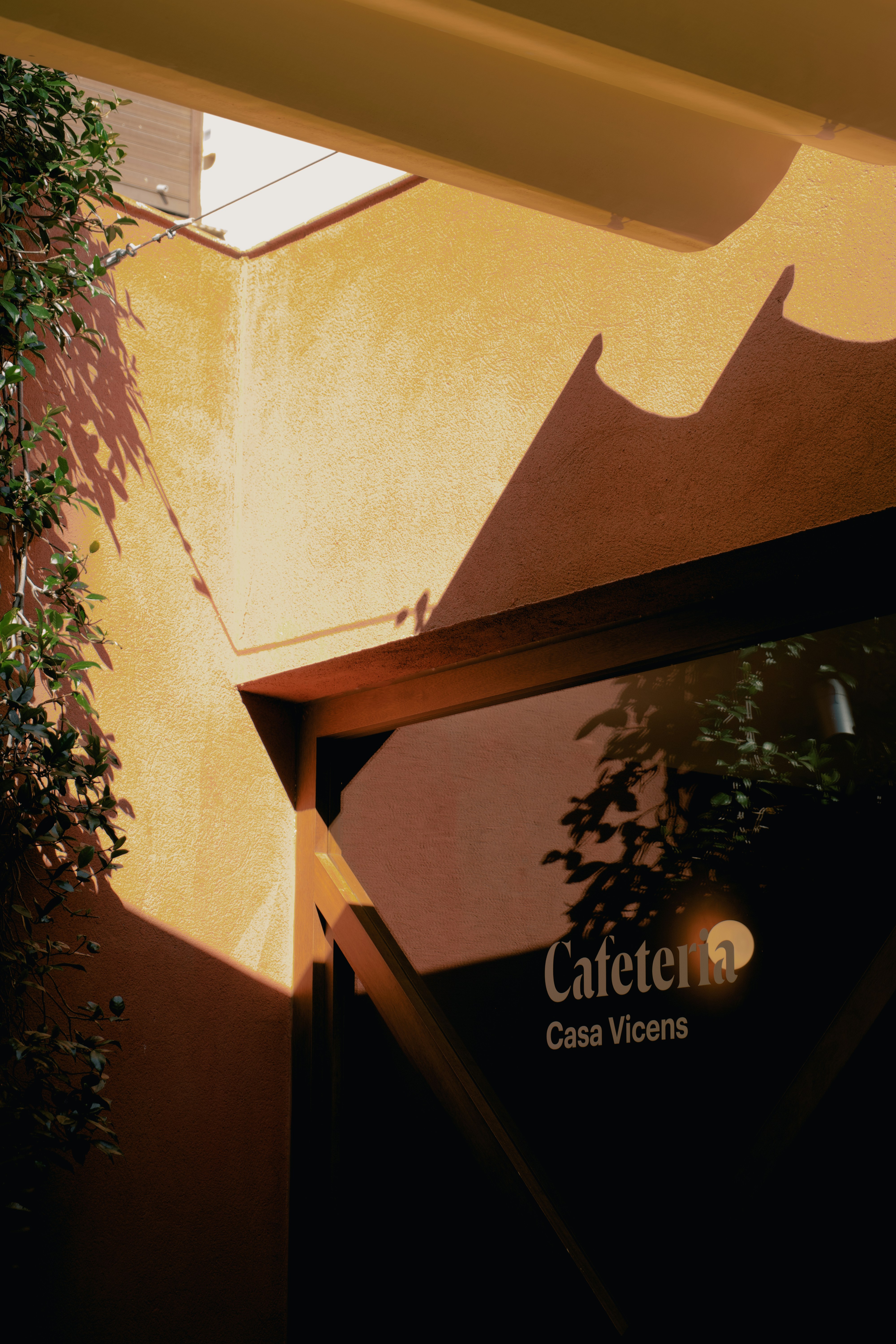 Cadmium Light on an Orange Facade: Café Vicens Entrance