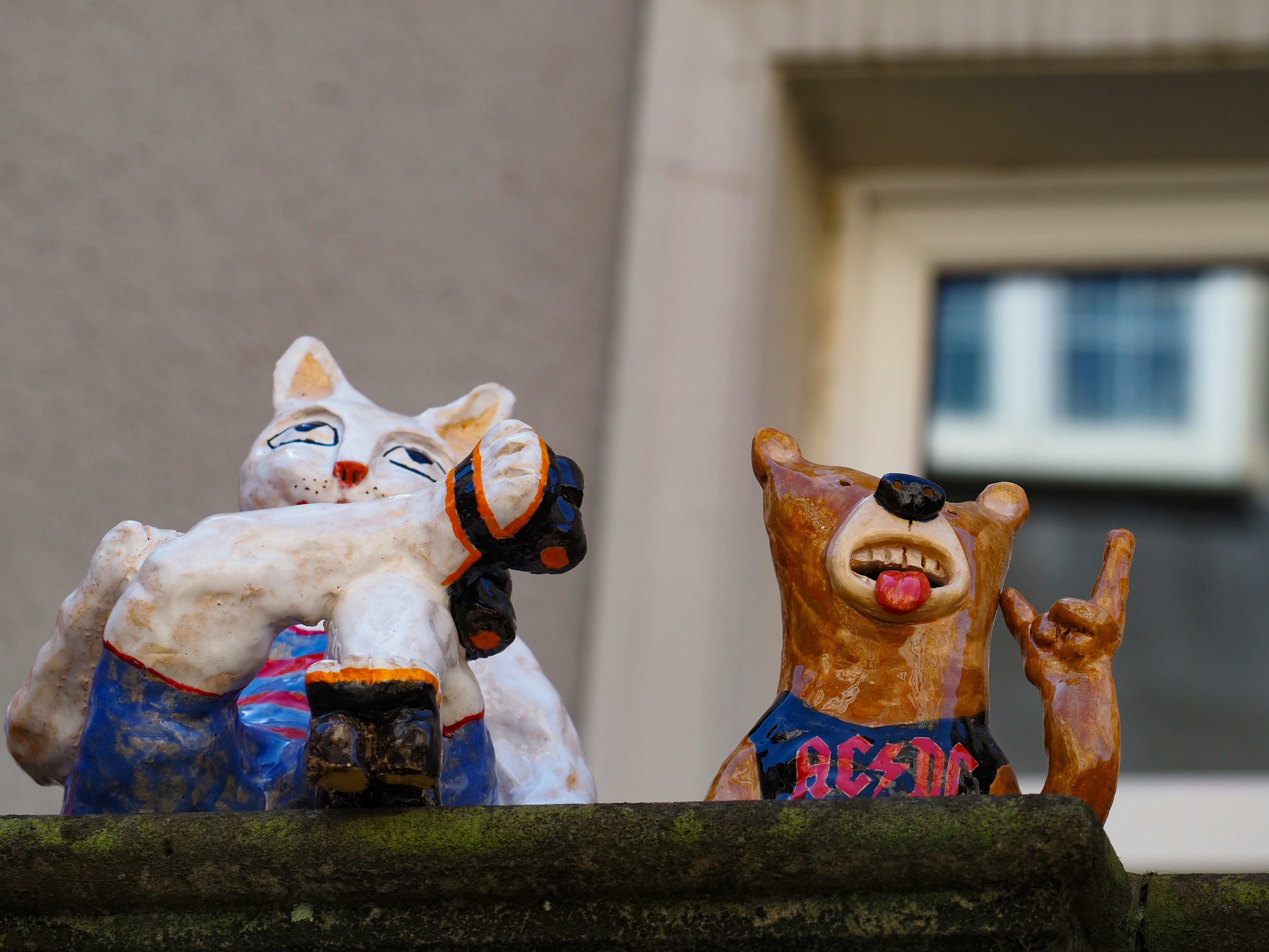 AC/DC Bear and Laughing Cat on a Mossy Windowsill