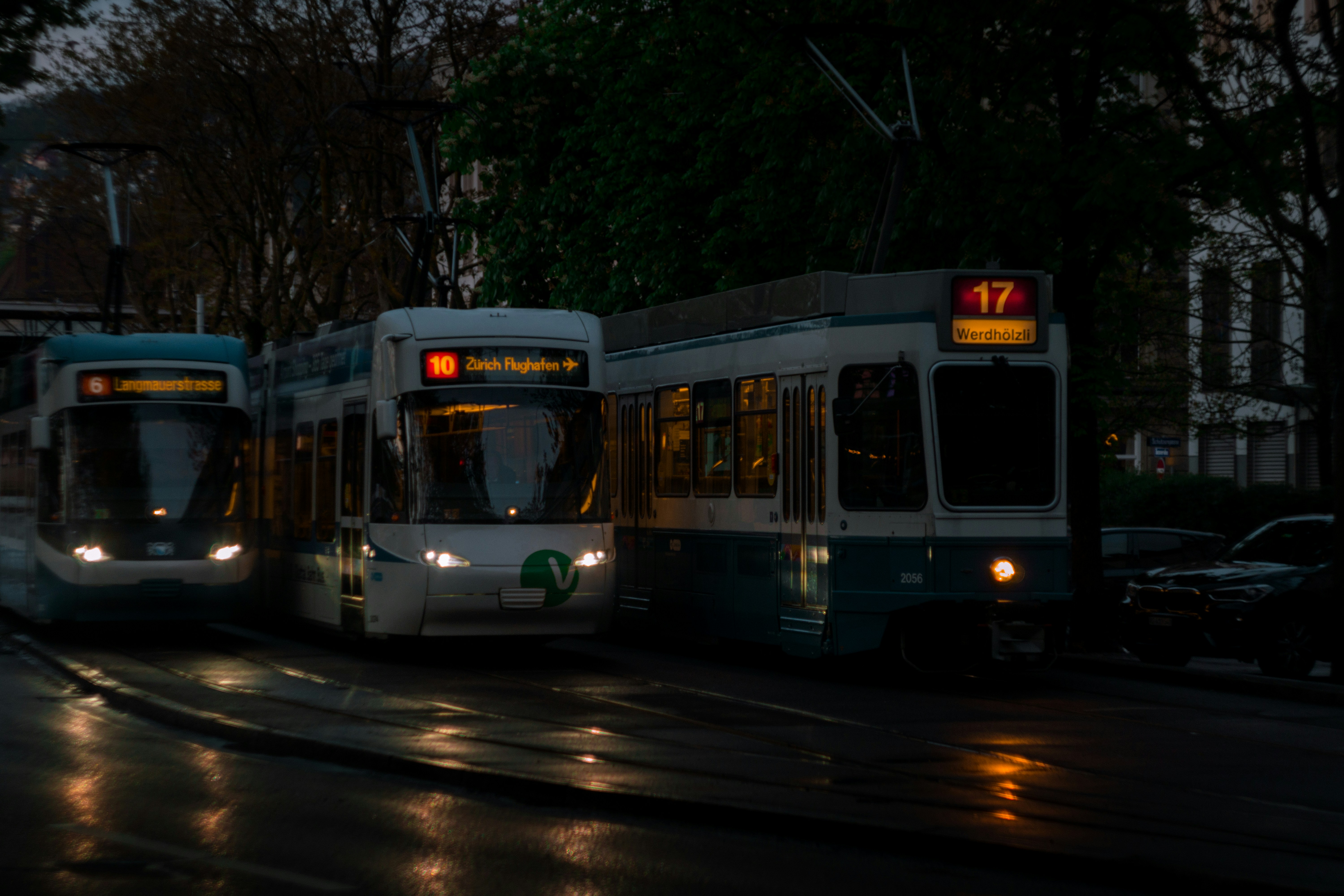 Nocturnal Trams Converge on a Rain-Wet City Track