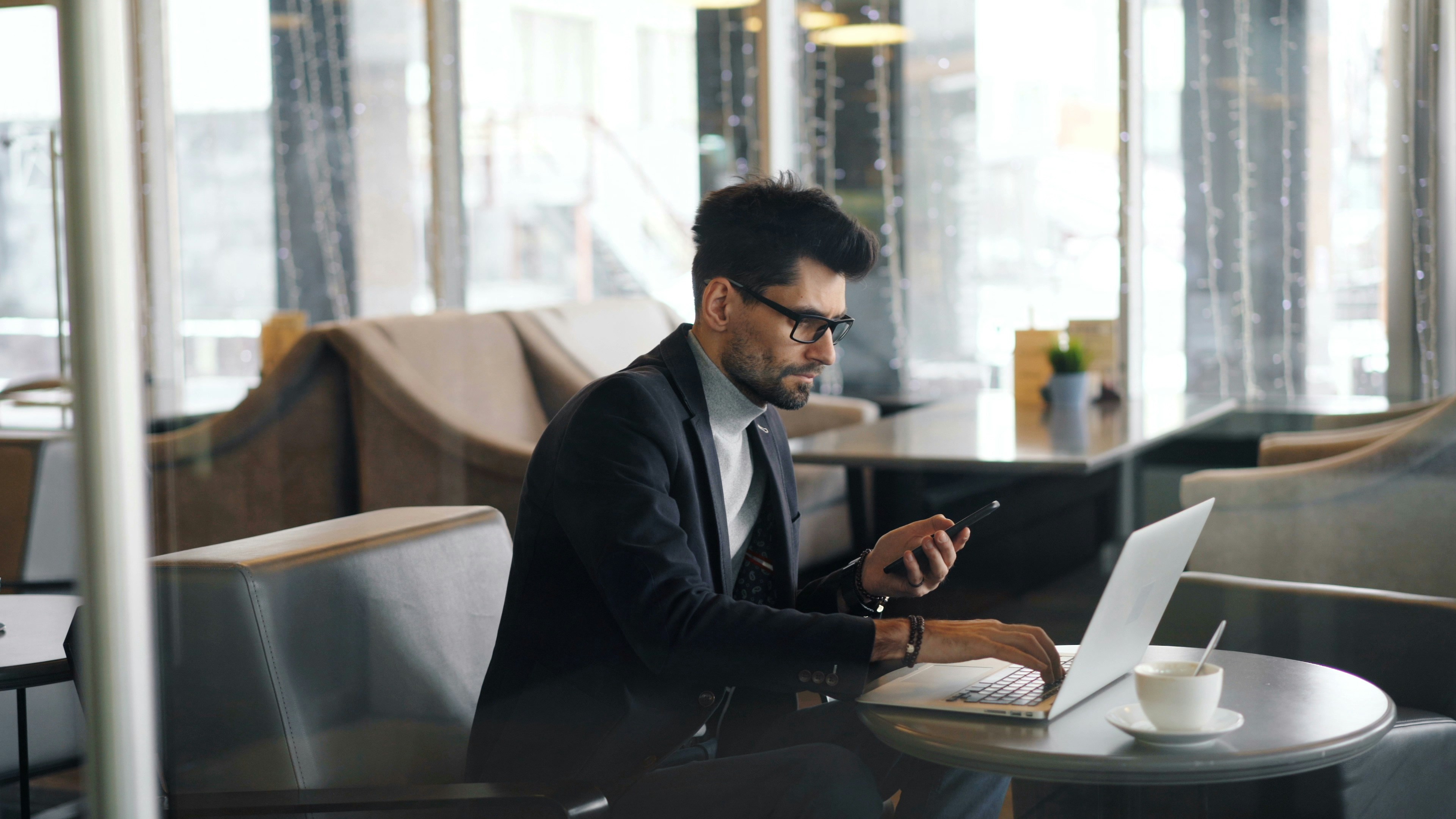 A man sitting at a table using a laptop computer photo – Free Coffee ...