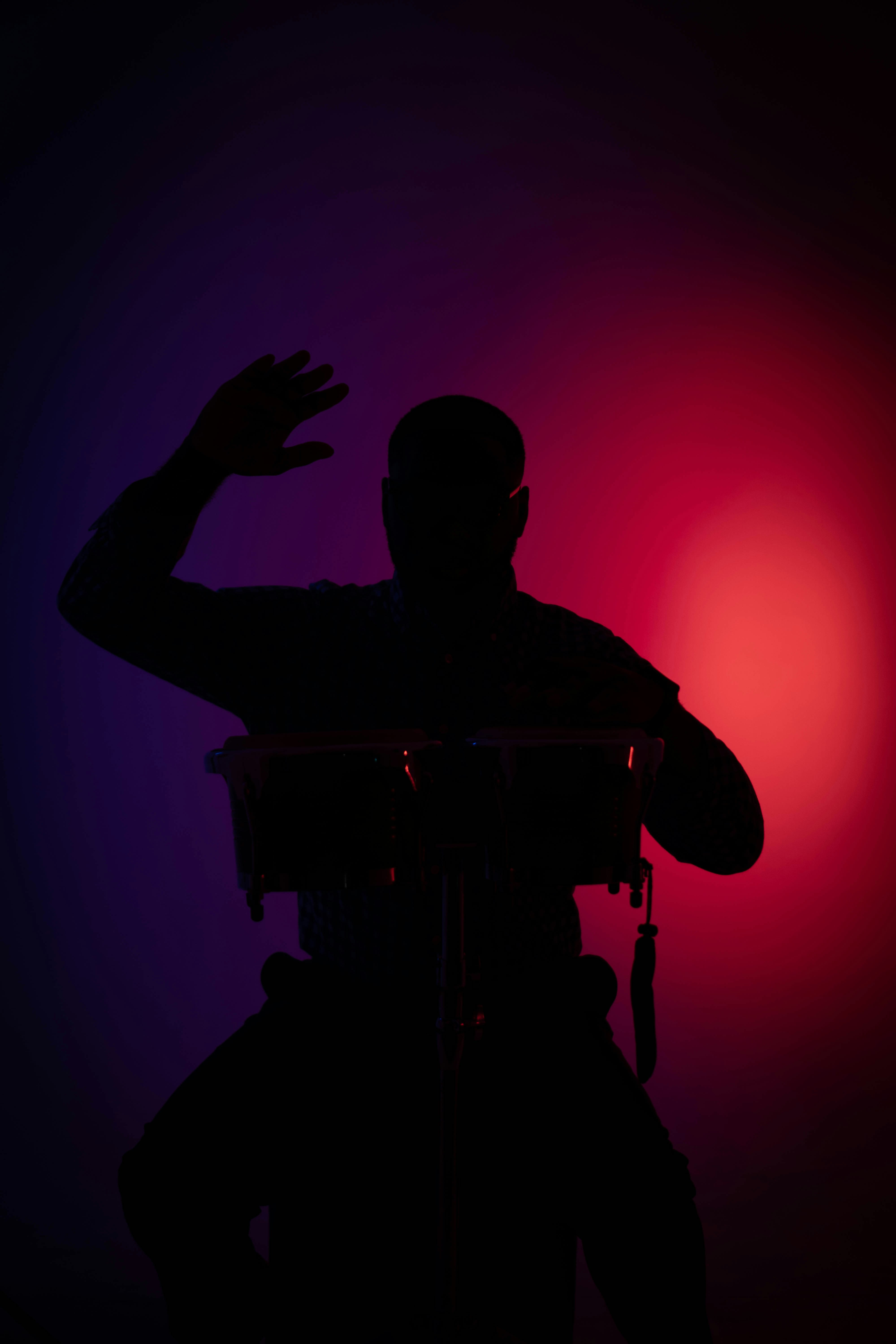 Neon Backbeat: Silhouette Drummer Under Crimson Glow