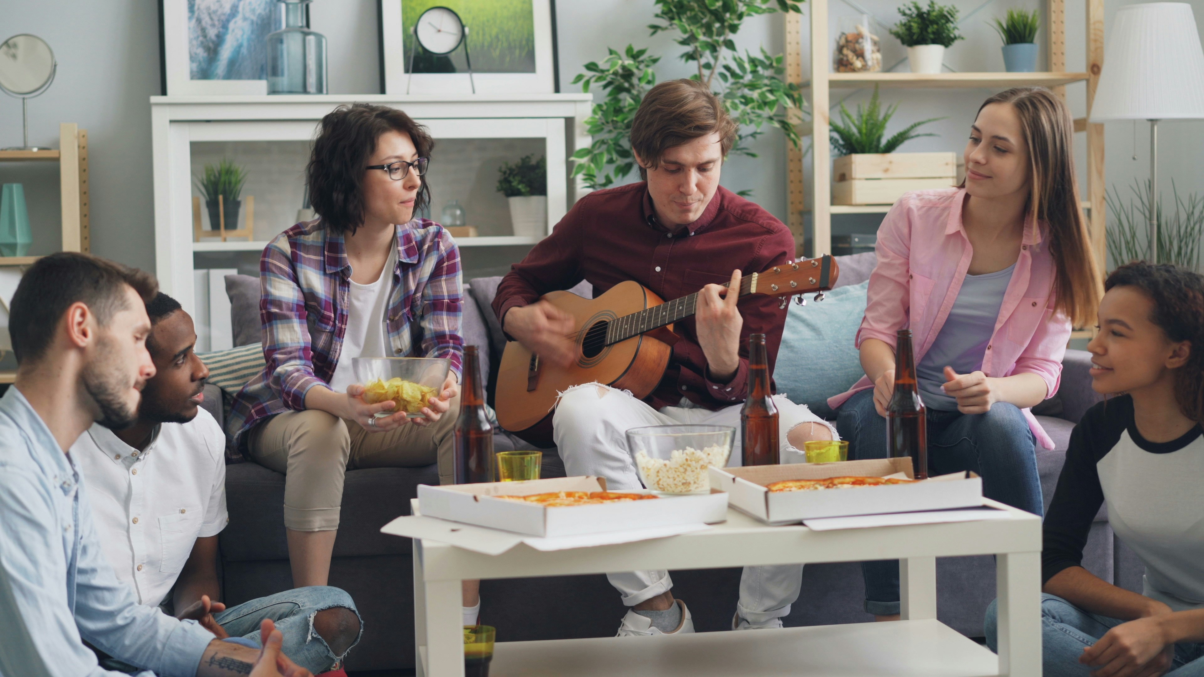A group of people sitting around a living room together photo – Free ...
