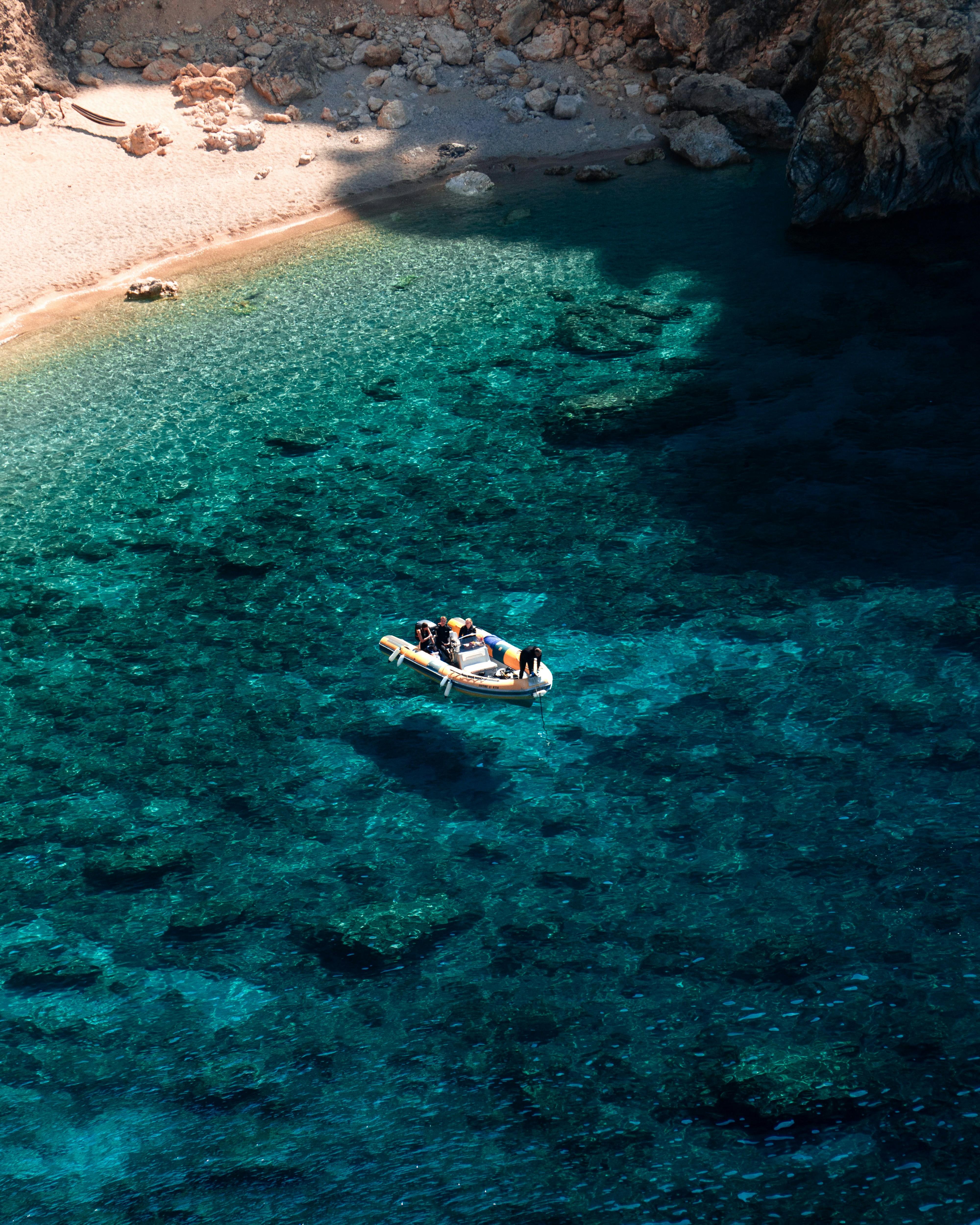 Boat in Greece | a couple of people in a small boat on a body of water