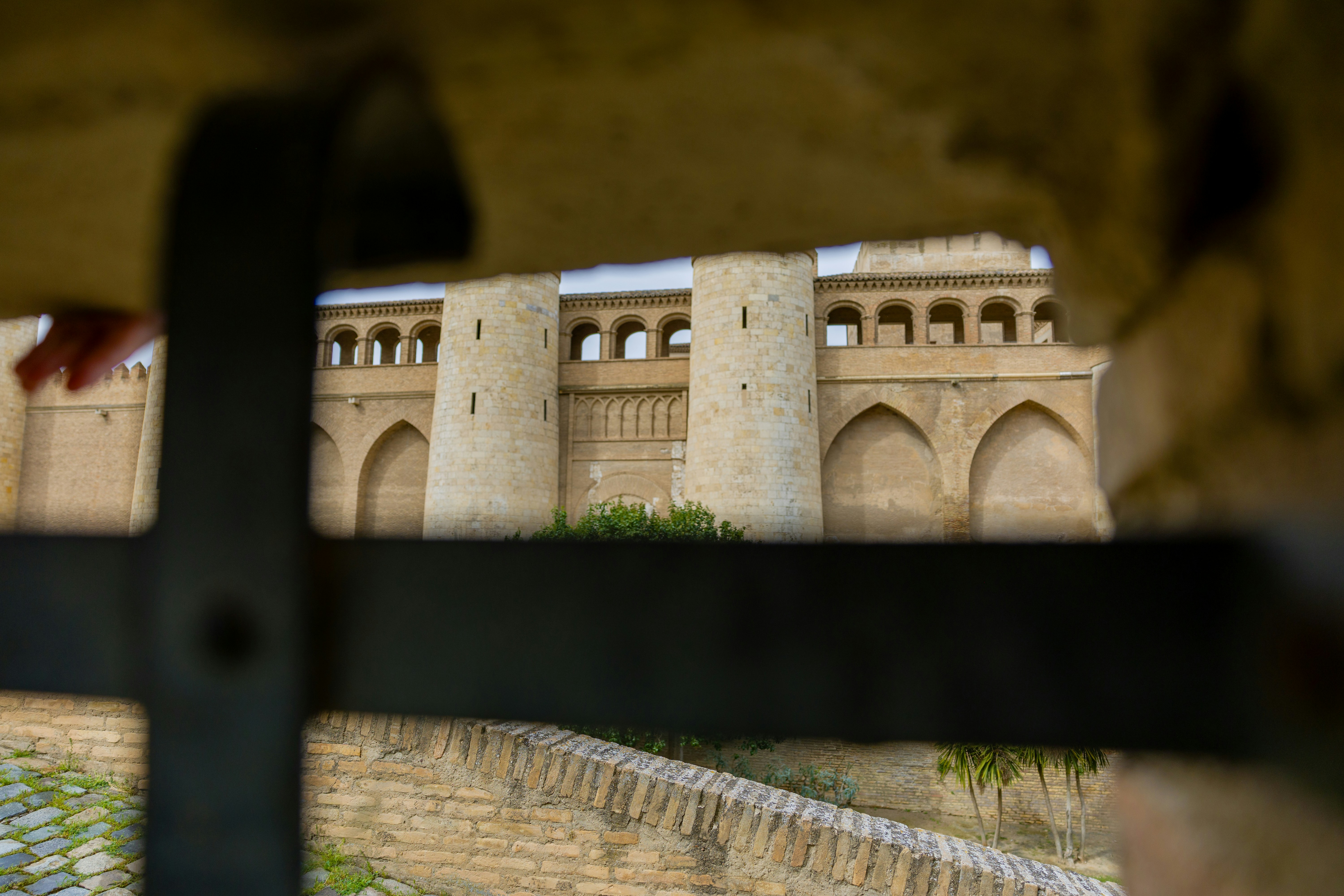 Framed Arches: A Medieval Facade Through a Weathered Grille
