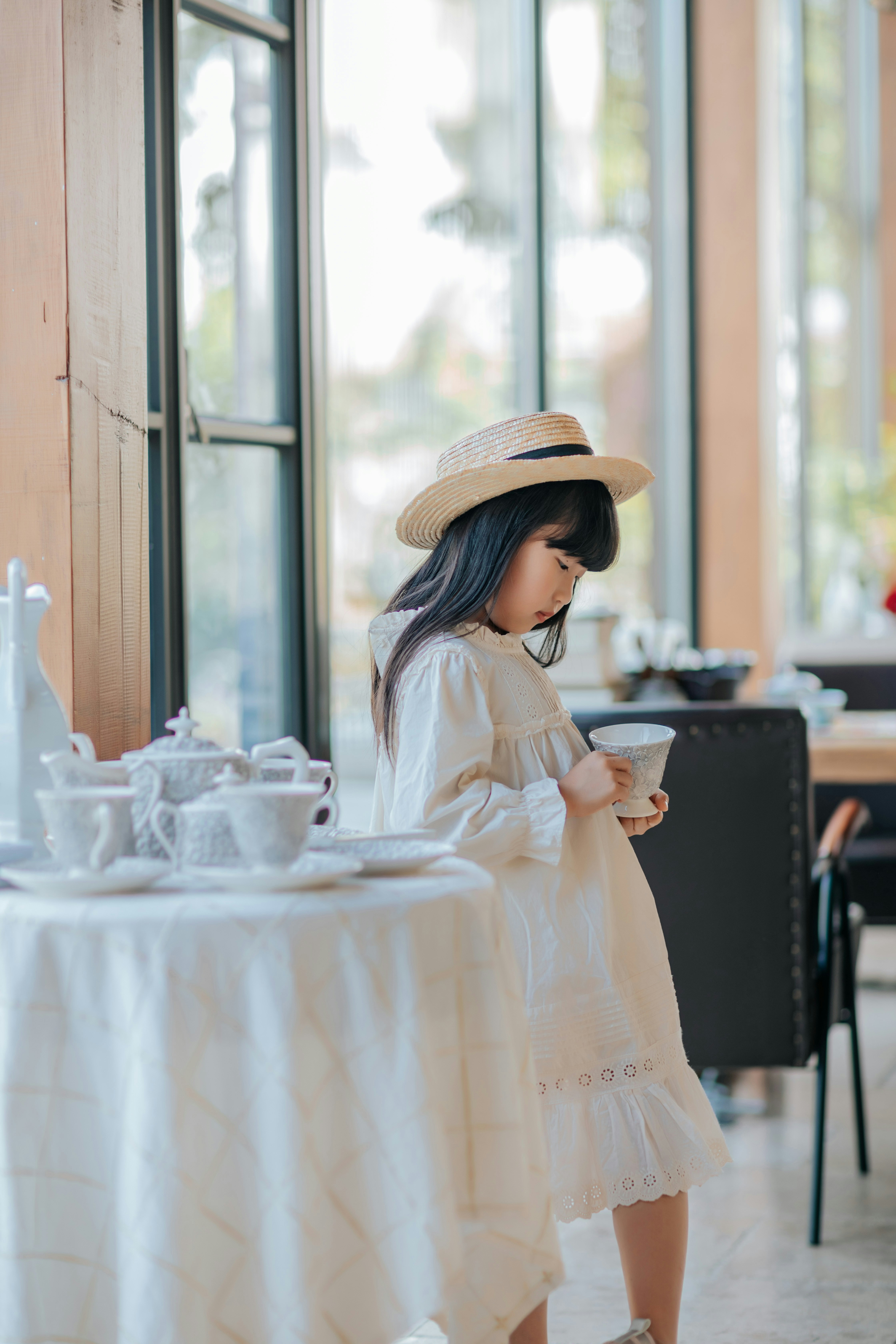 Tea by the Window: A Quiet Moment with a Straw Hat