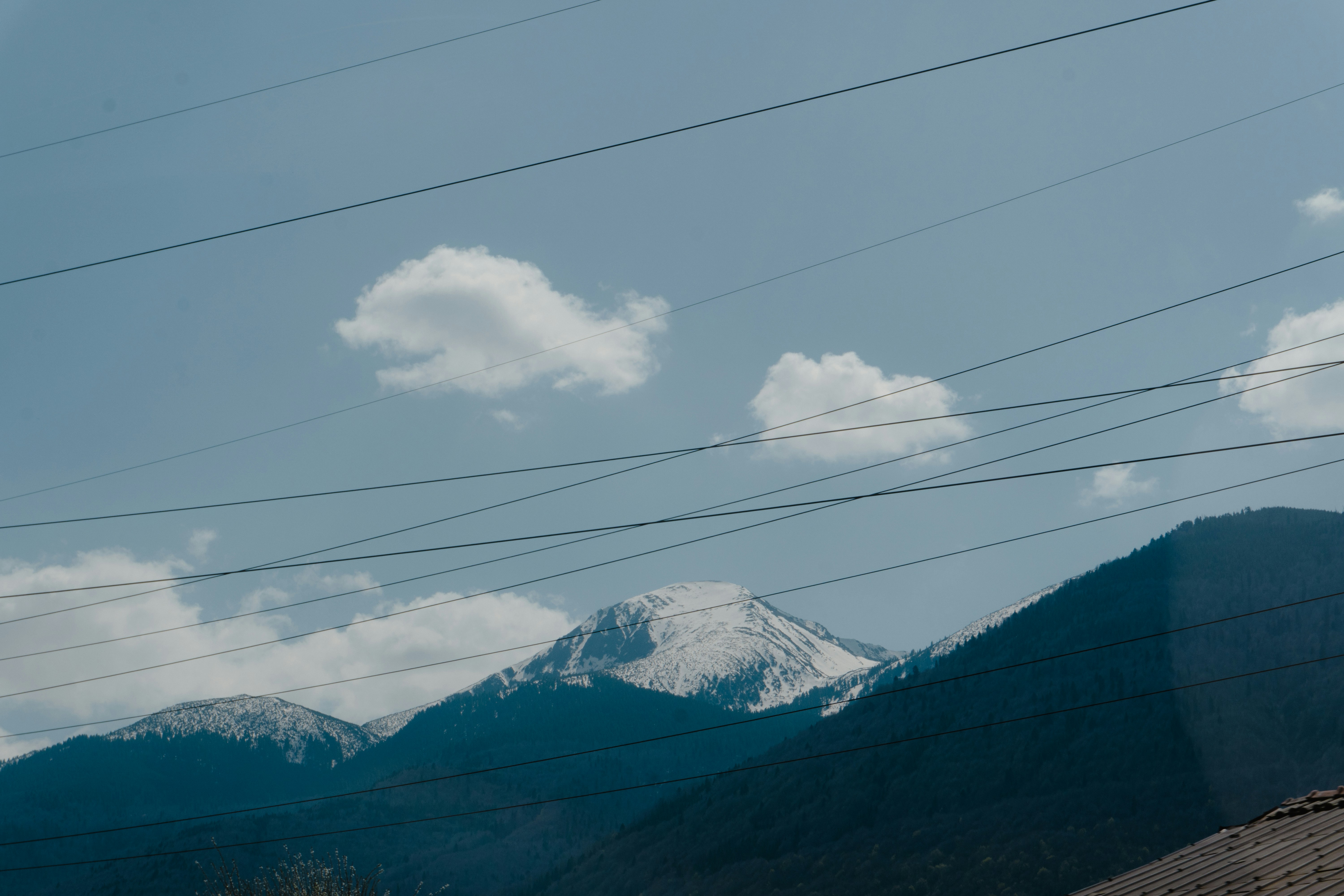 Alpine Crowned Peaks Threaded by Wires Under a Quiet Blue Sky