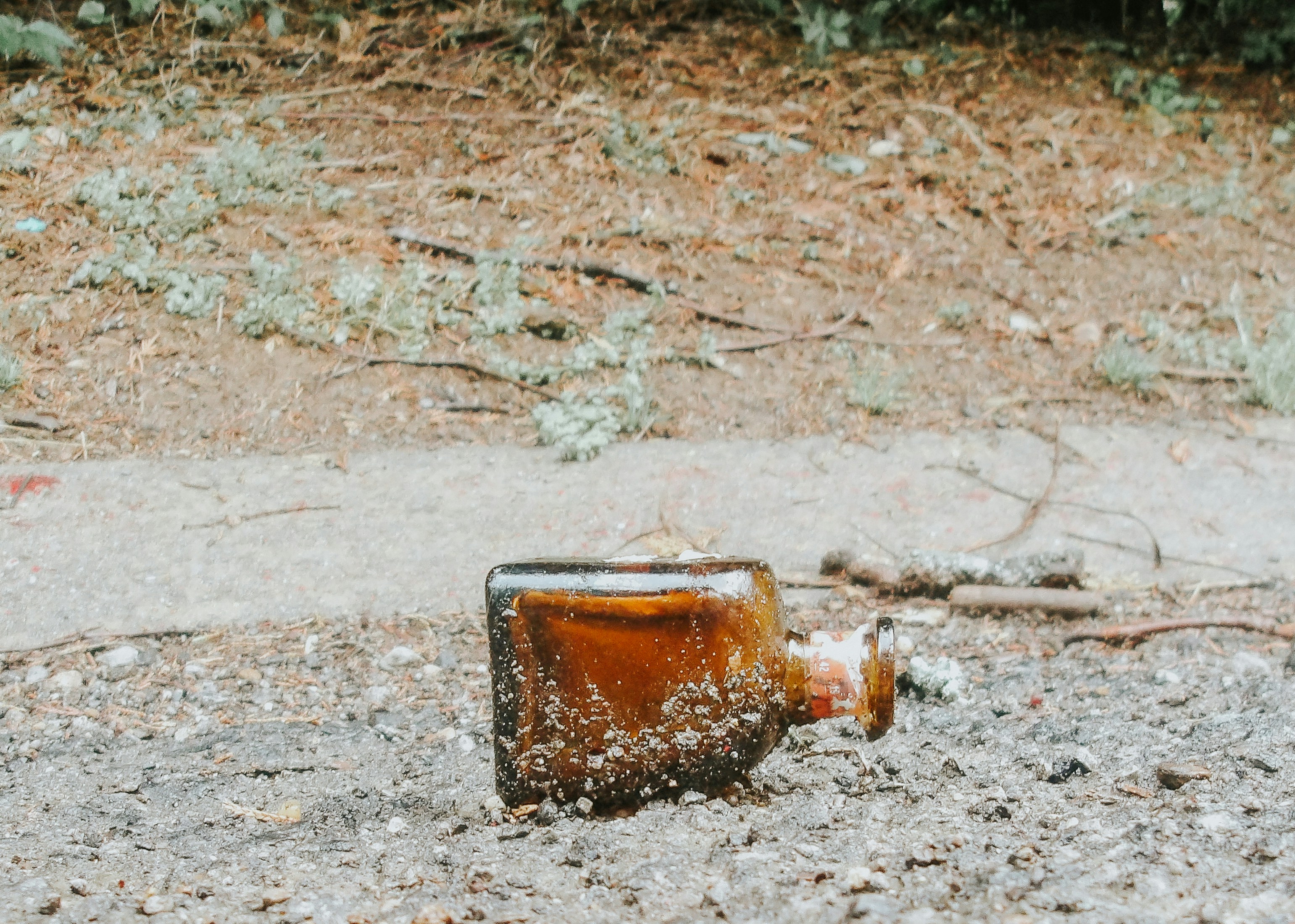Amber Bottle on a Gravel Stage: A Quiet Outdoor Relic