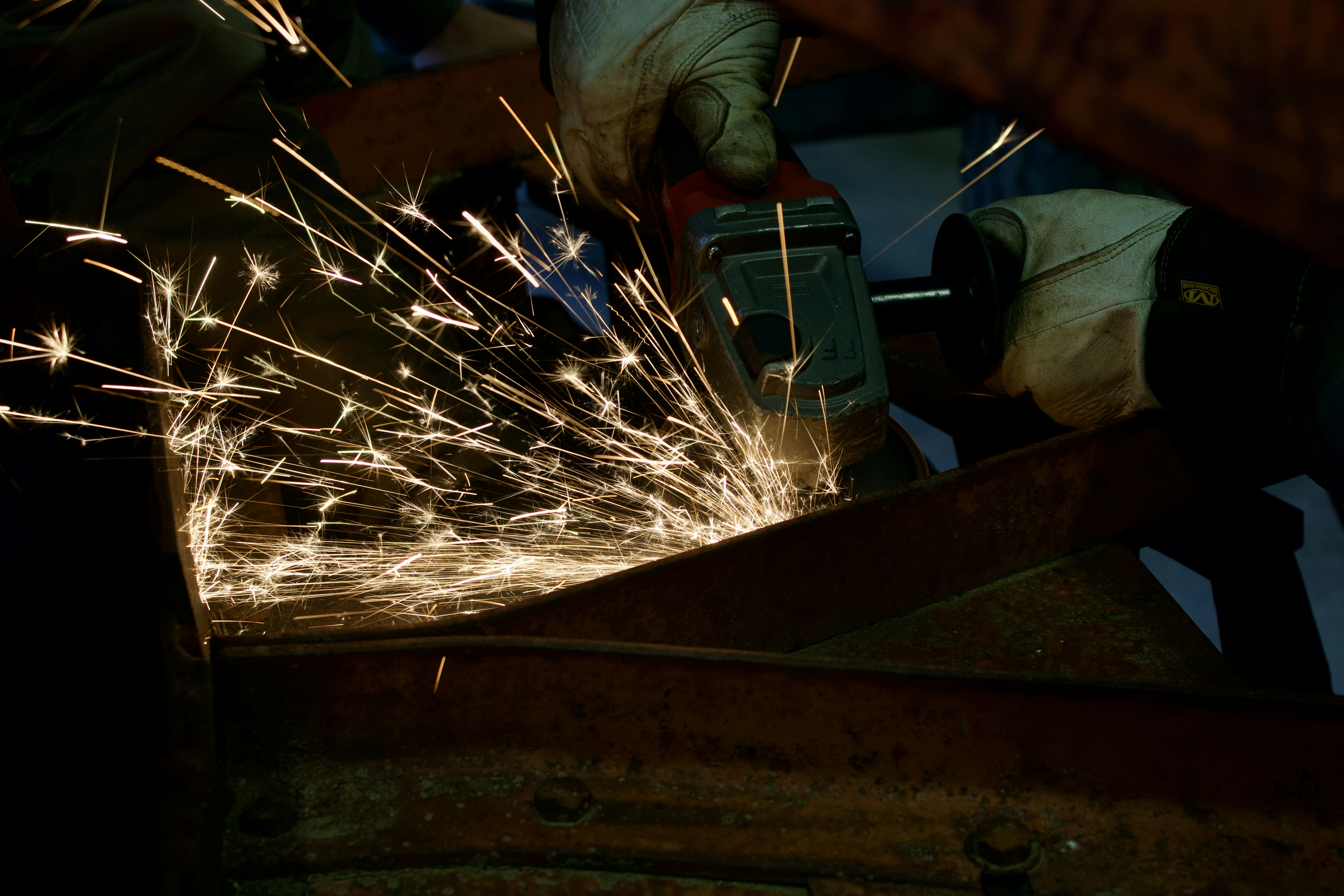 A person using a grinder on a piece of metal photo – Free Person Image ...
