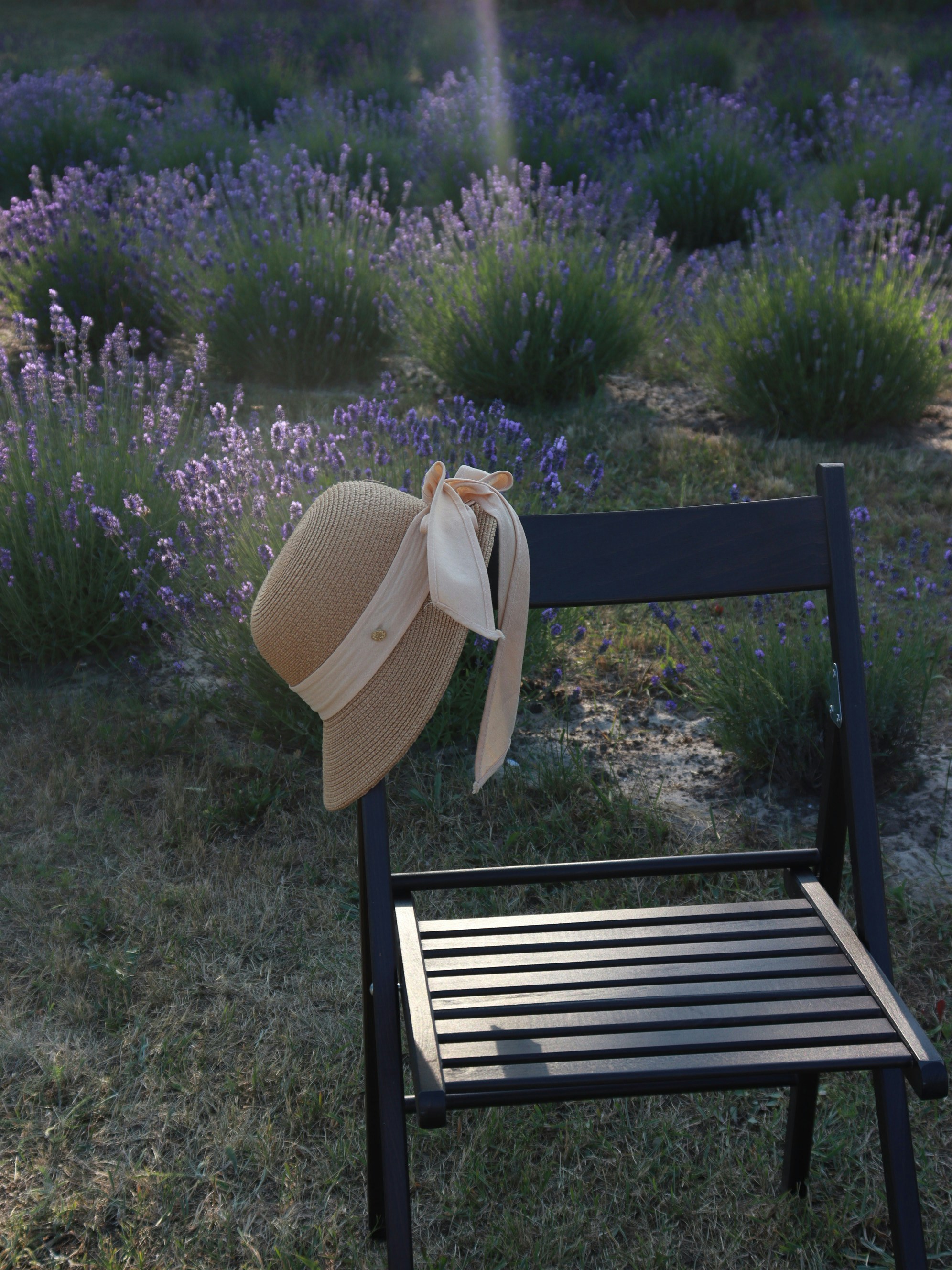 Stillness in Lavender: A Hat Dangles from a Quiet Chair