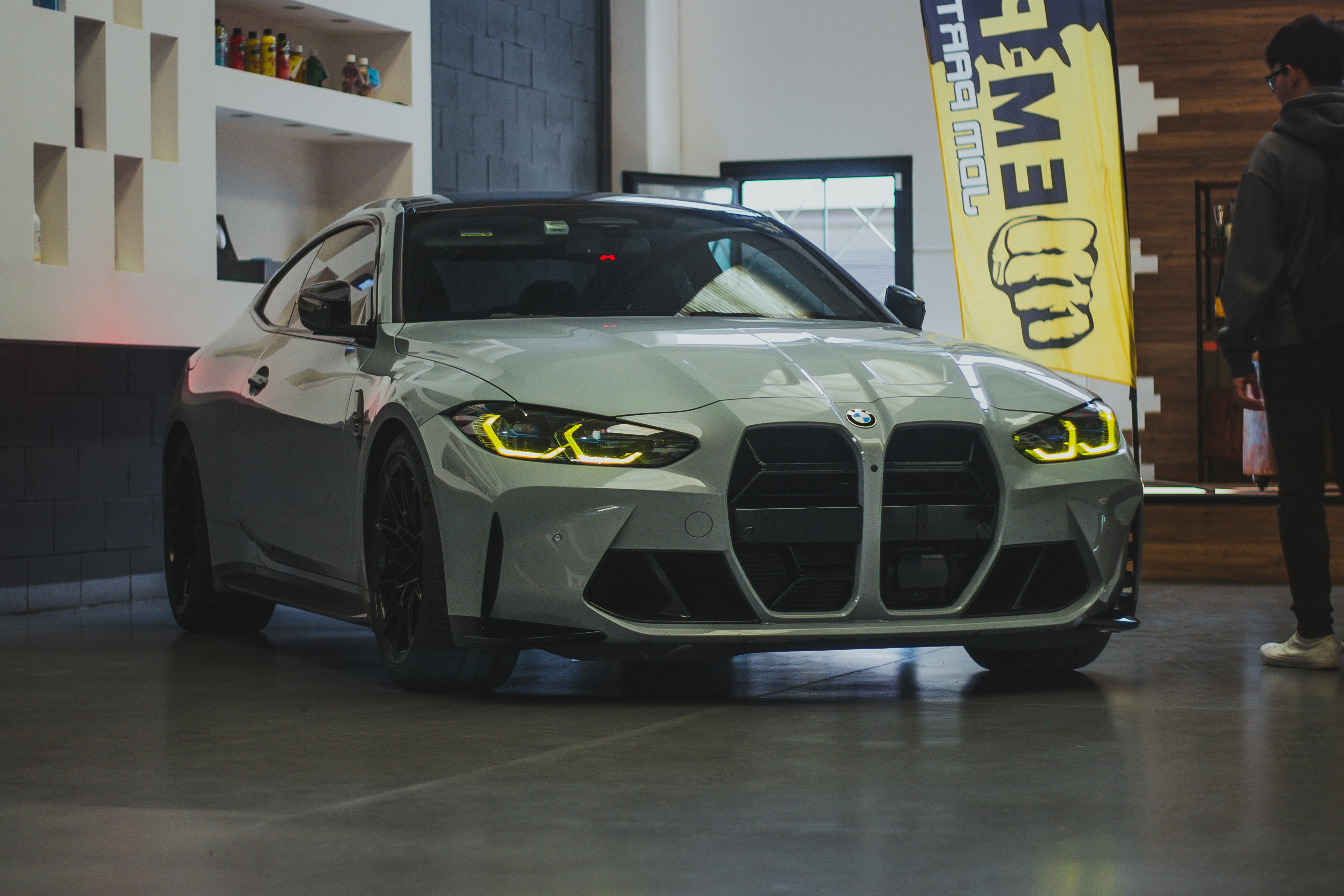 Midnight Alpine: A BMW M4 in Spotlight Inside a Modern Showroom