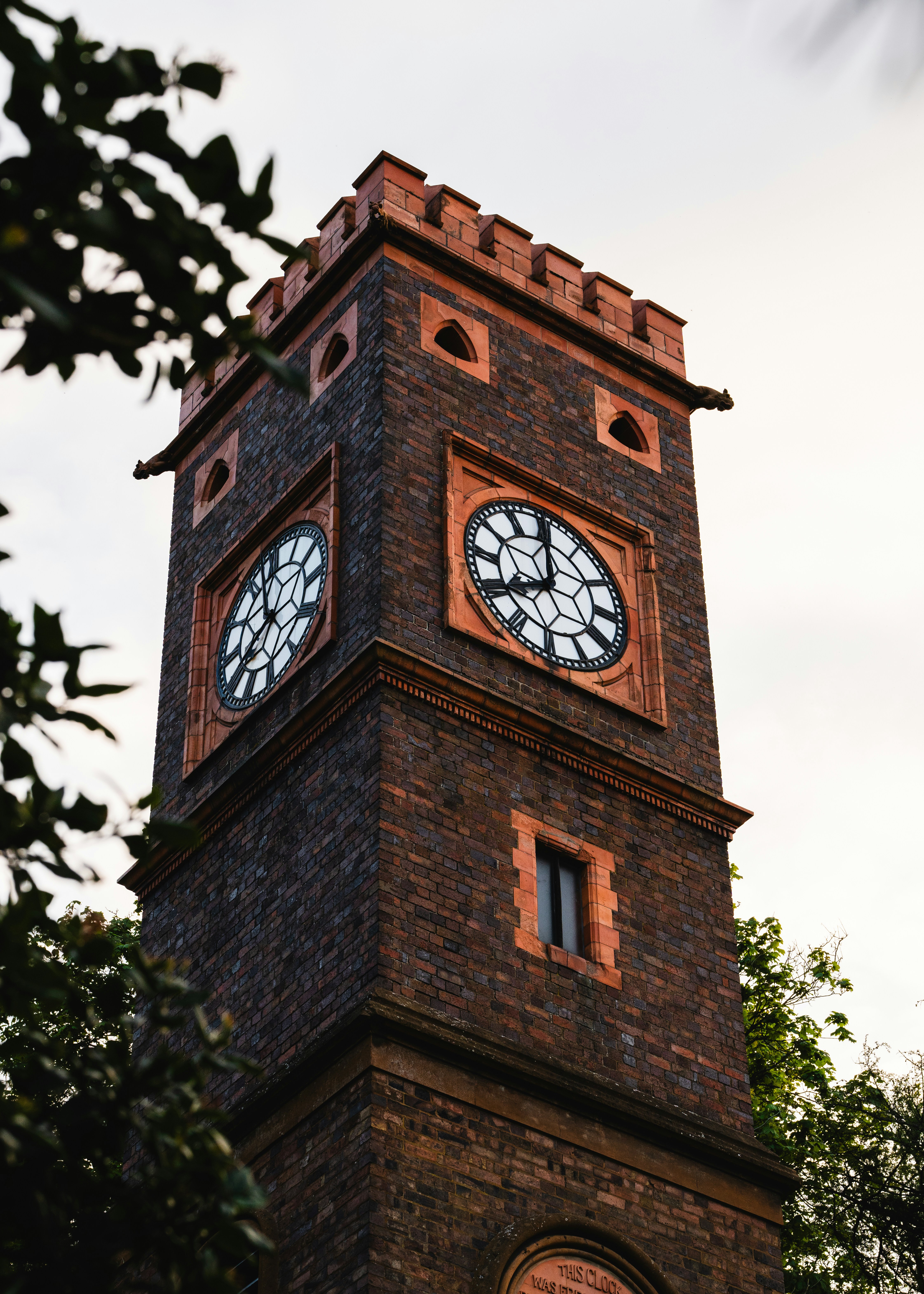 A tall brick clock tower with a clock on each of it's sides photo ...