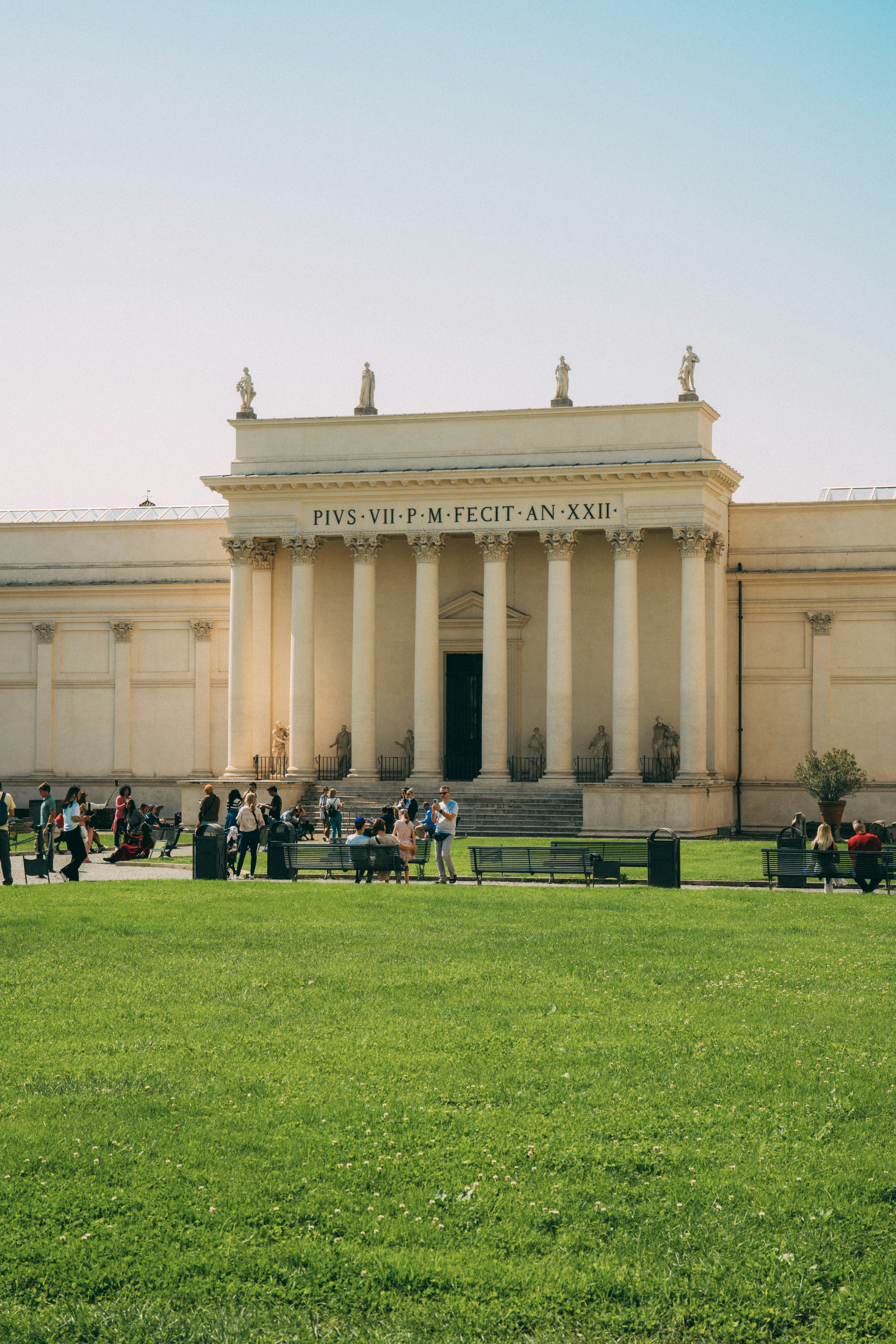 Sunlit Colonnade Gateway: Visitors Before a Classical Facade