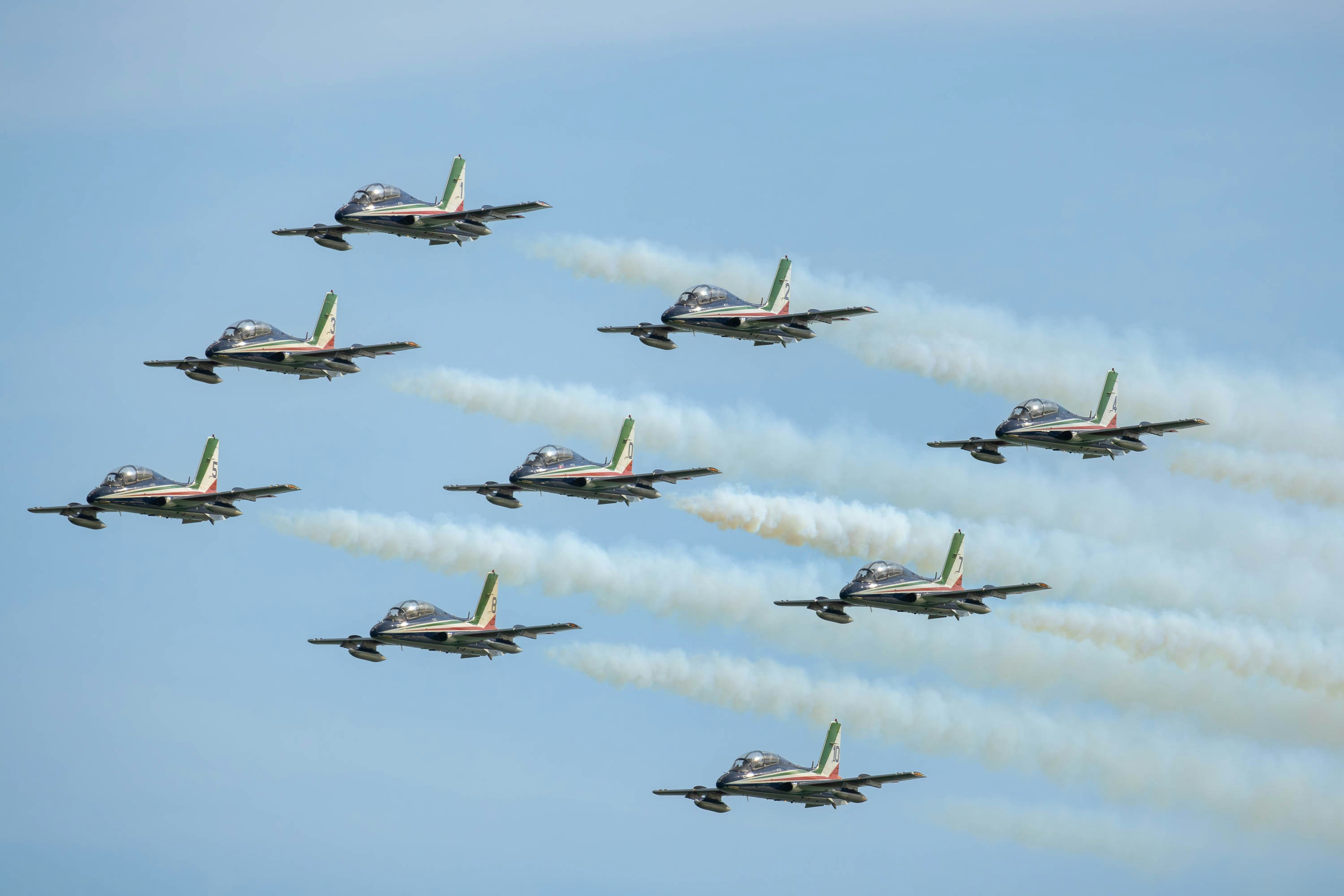 A group of jets flying in formation with smoke trailing behind them ...