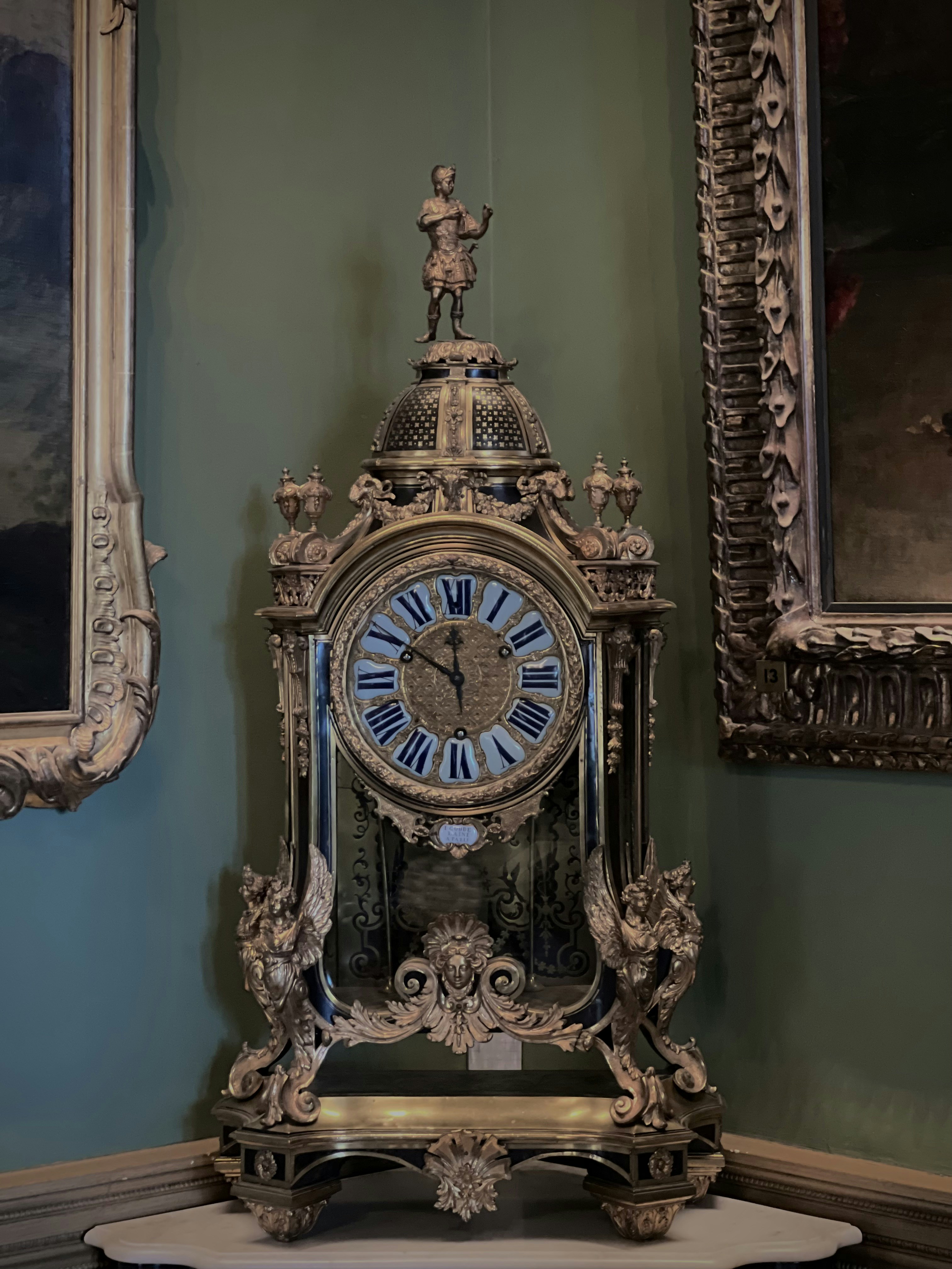 Timekeeper in the Gallery: An Intricate Baroque Clock Between Portrait Frames