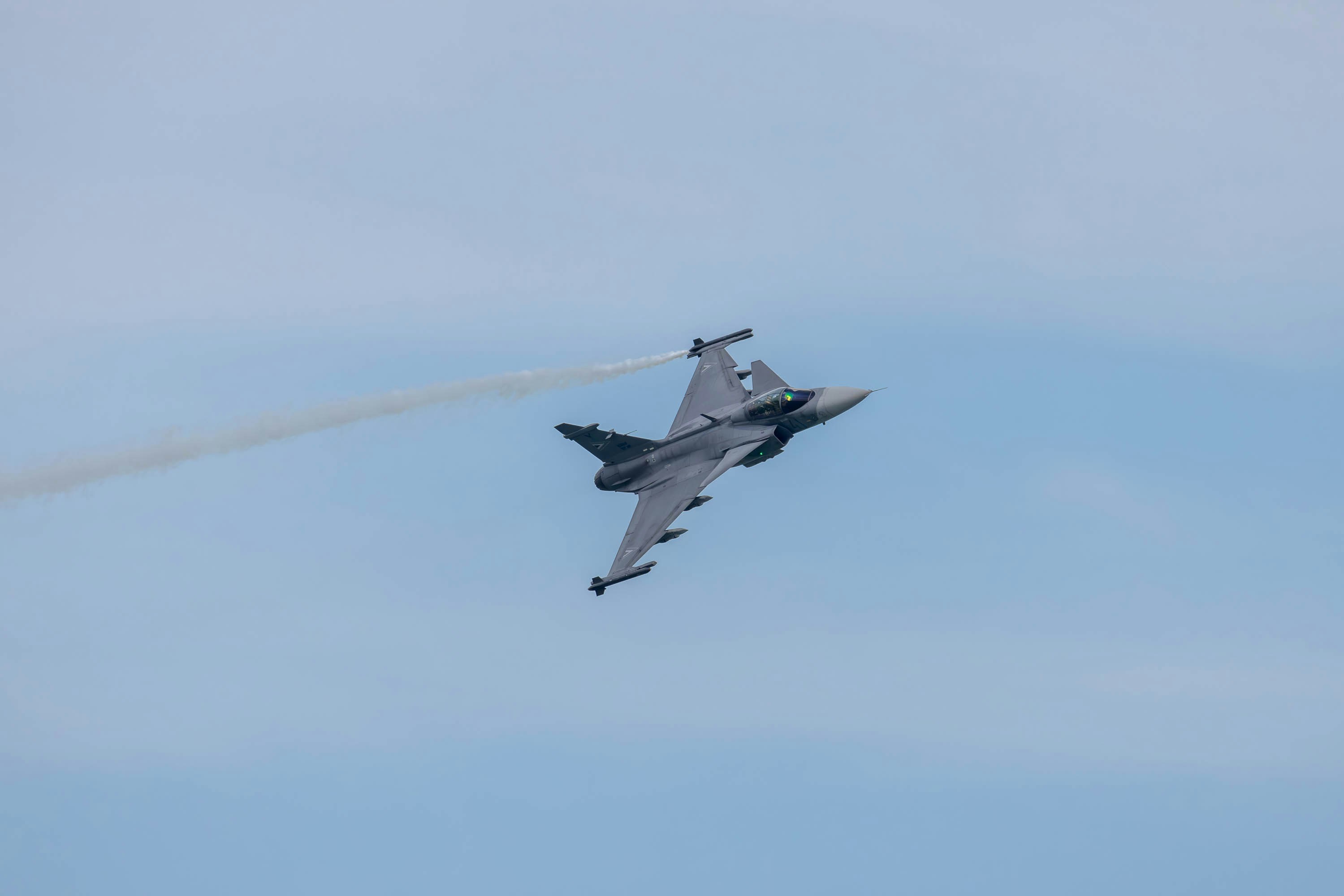 A fighter jet flying through a blue sky photo – Free Grey Image on Unsplash