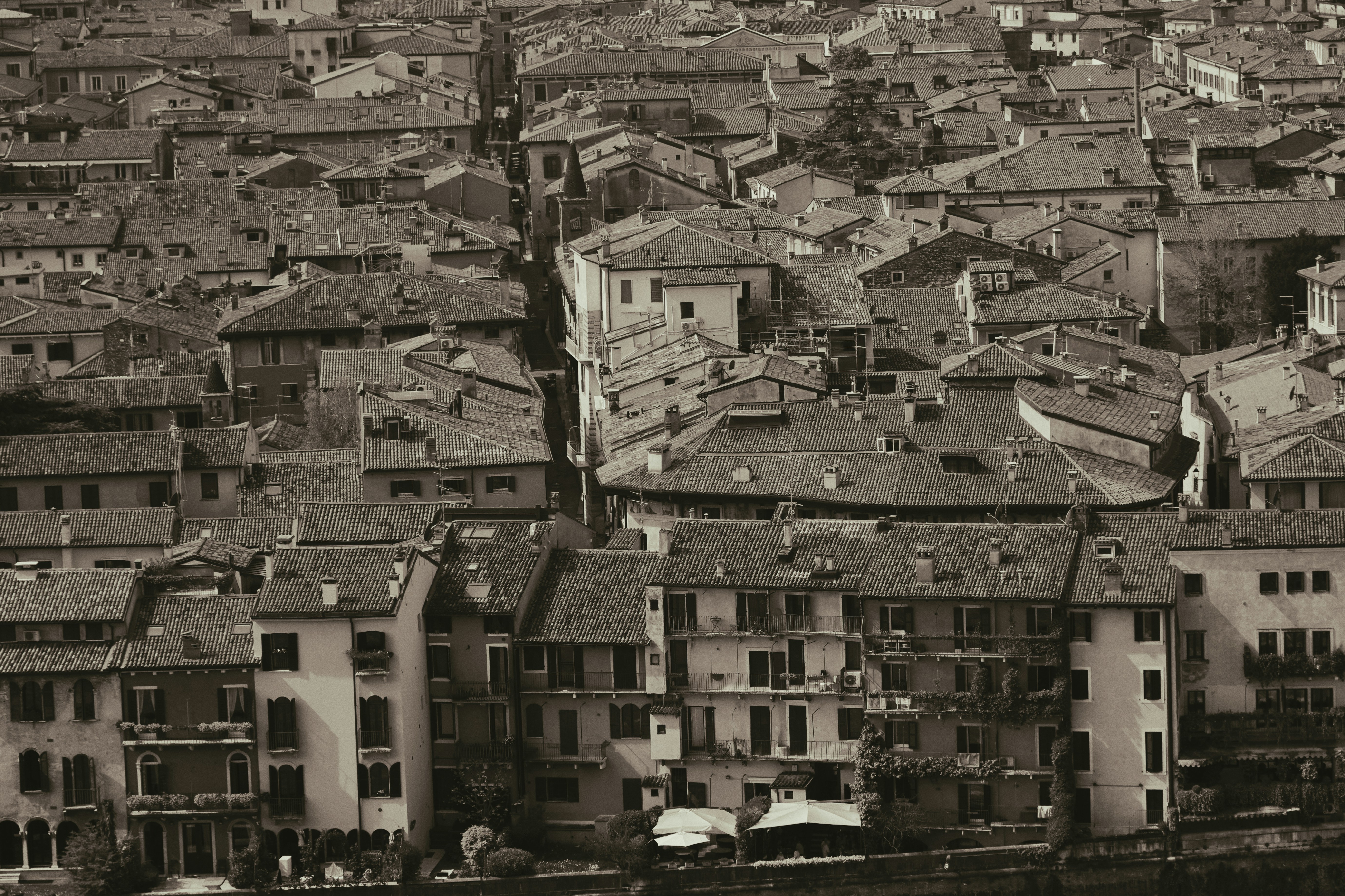 Sepia-toned view of densely packed rooftops in an old cityscape.