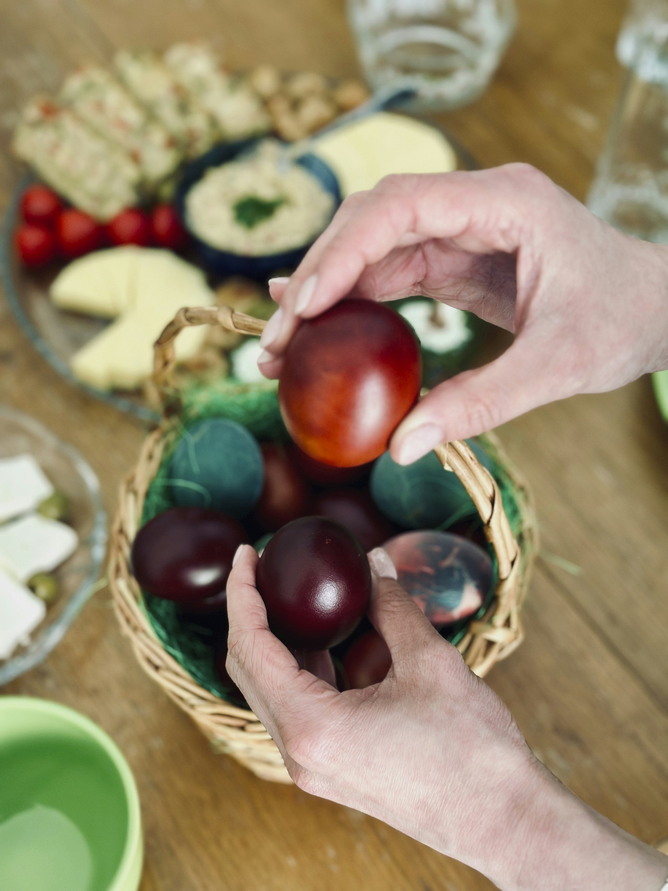 a person picking up a cherry from a basket
