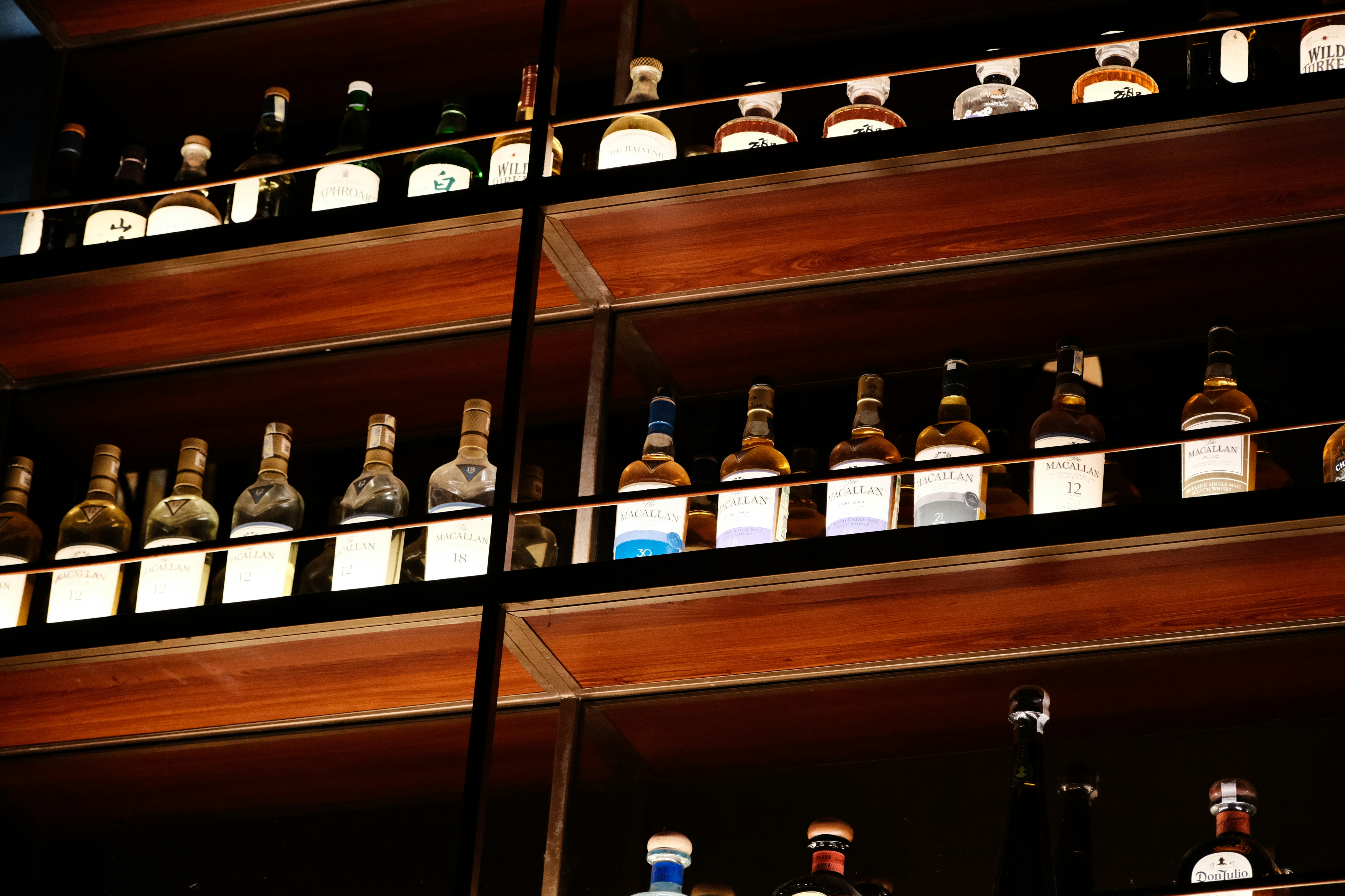 A shelf filled with lots of bottles of alcohol photo – Free Beverage ...