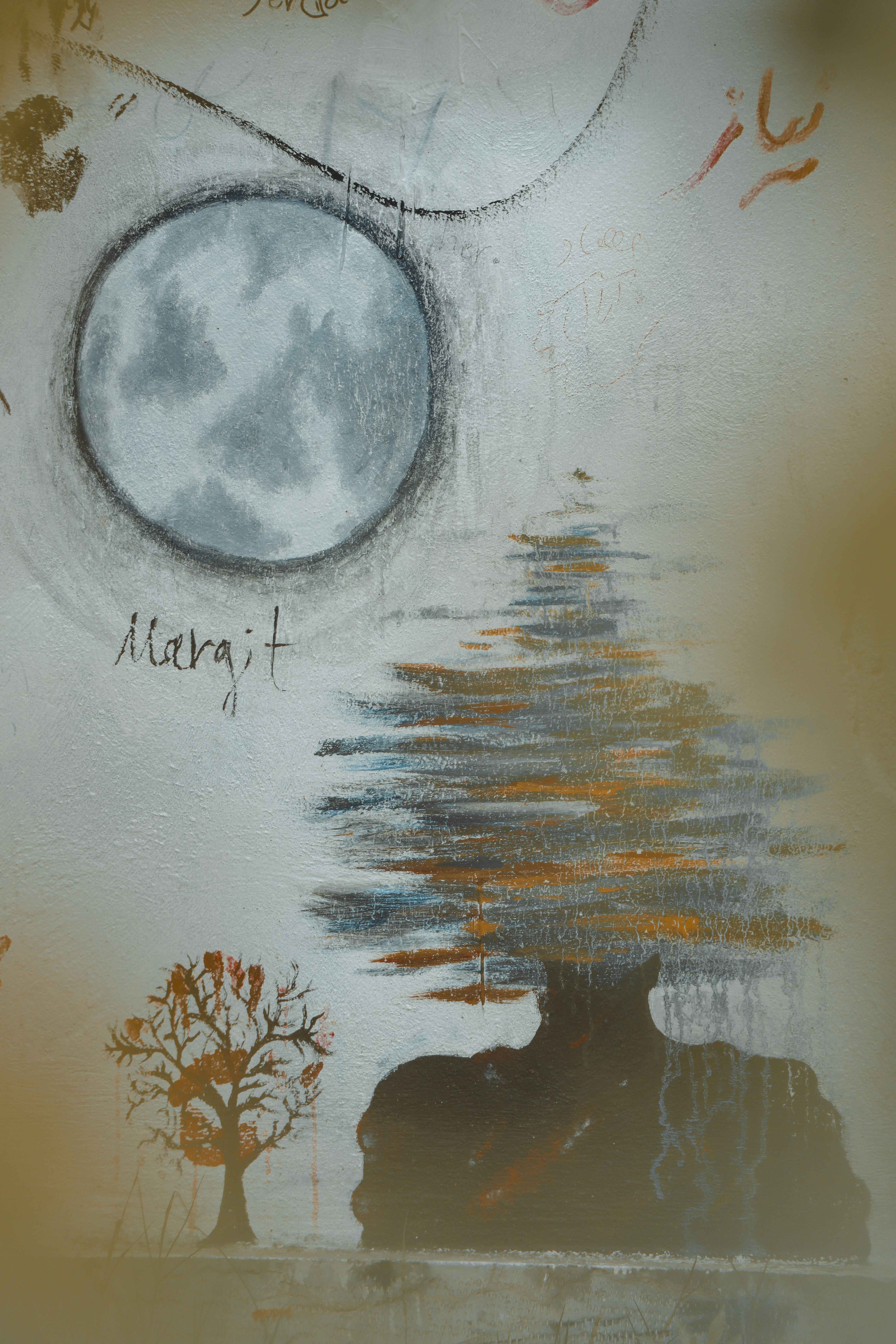 Circle Moon over Layered Tree and Rock on a Weathered Graffiti Wall
