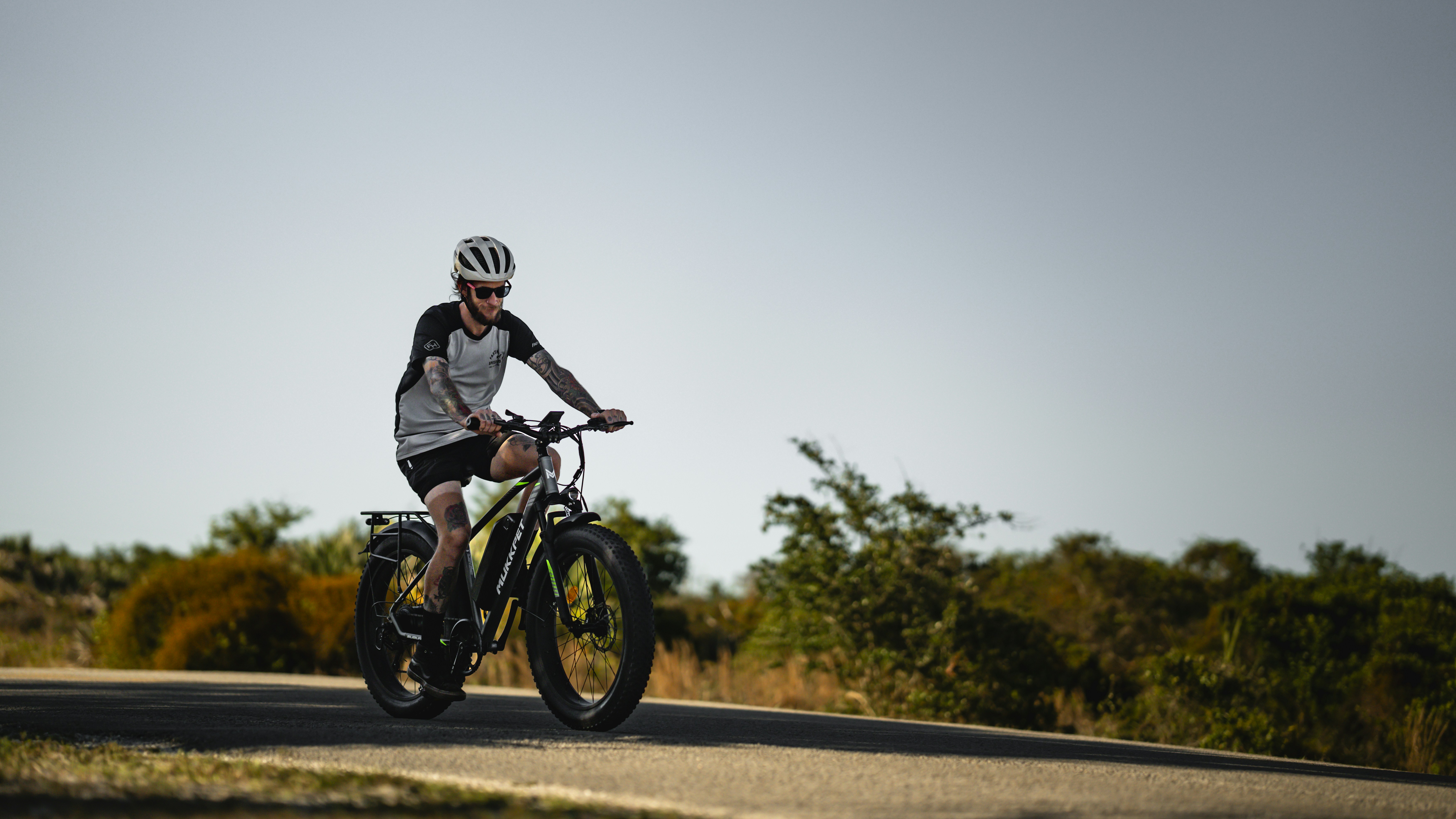 A man riding a bike down a rural road photo – Free Vehicle Image on ...