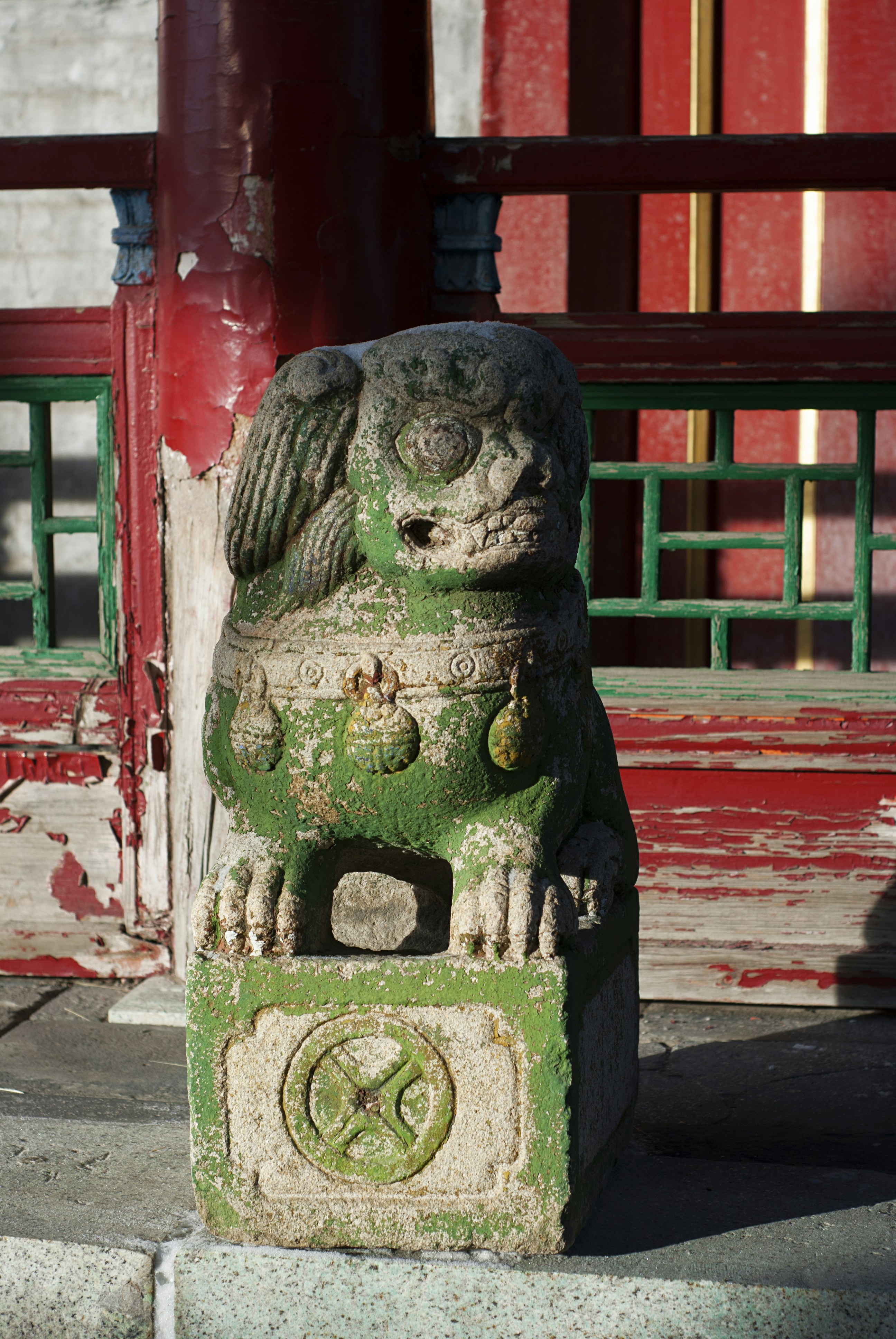 Moss-Cloaked Foo Dog Guarding a Red-Trimmed Temple Rail