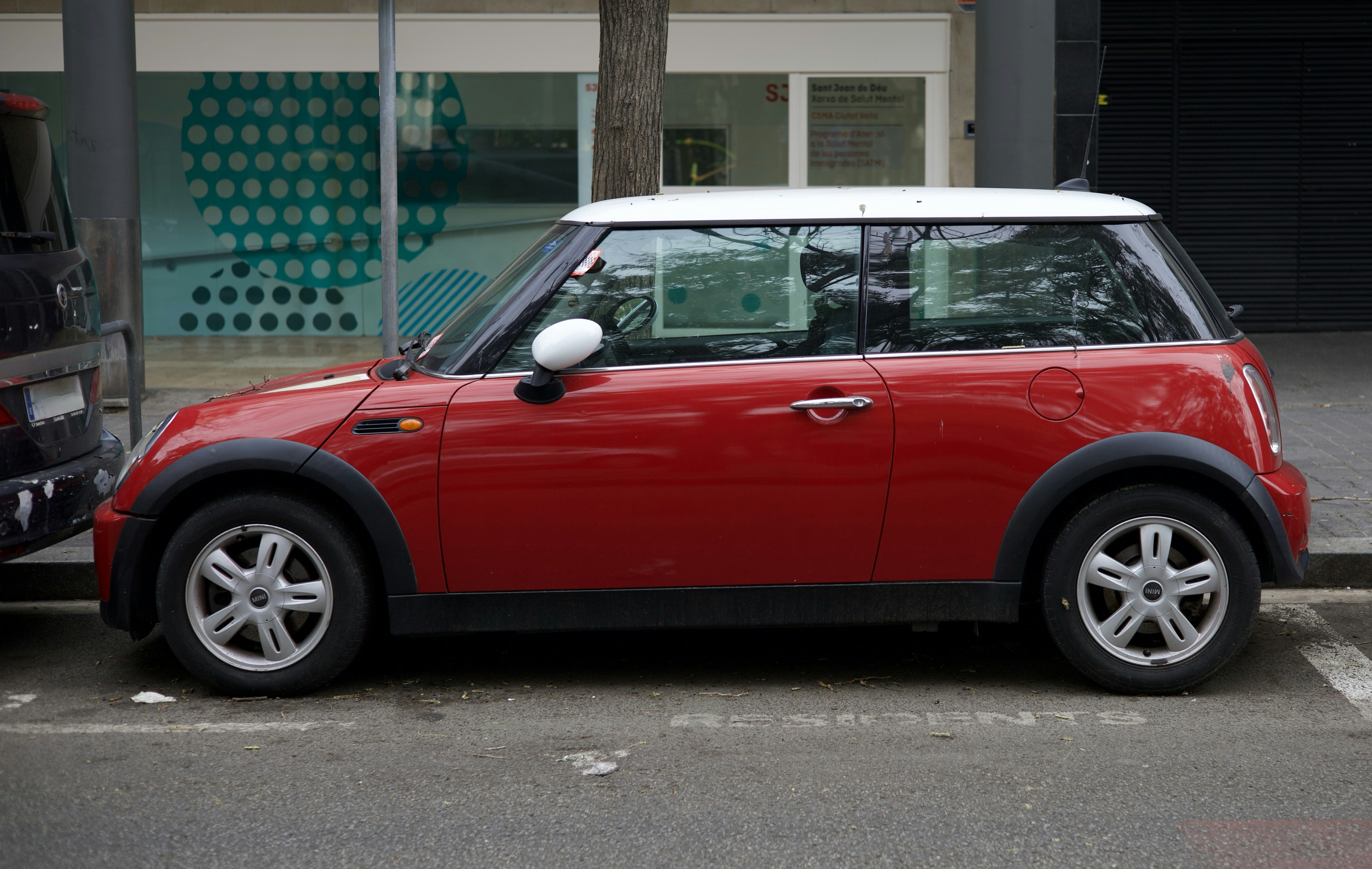 Scarlet City Profile: A Red Compact Parked Along a Glass-Front Street
