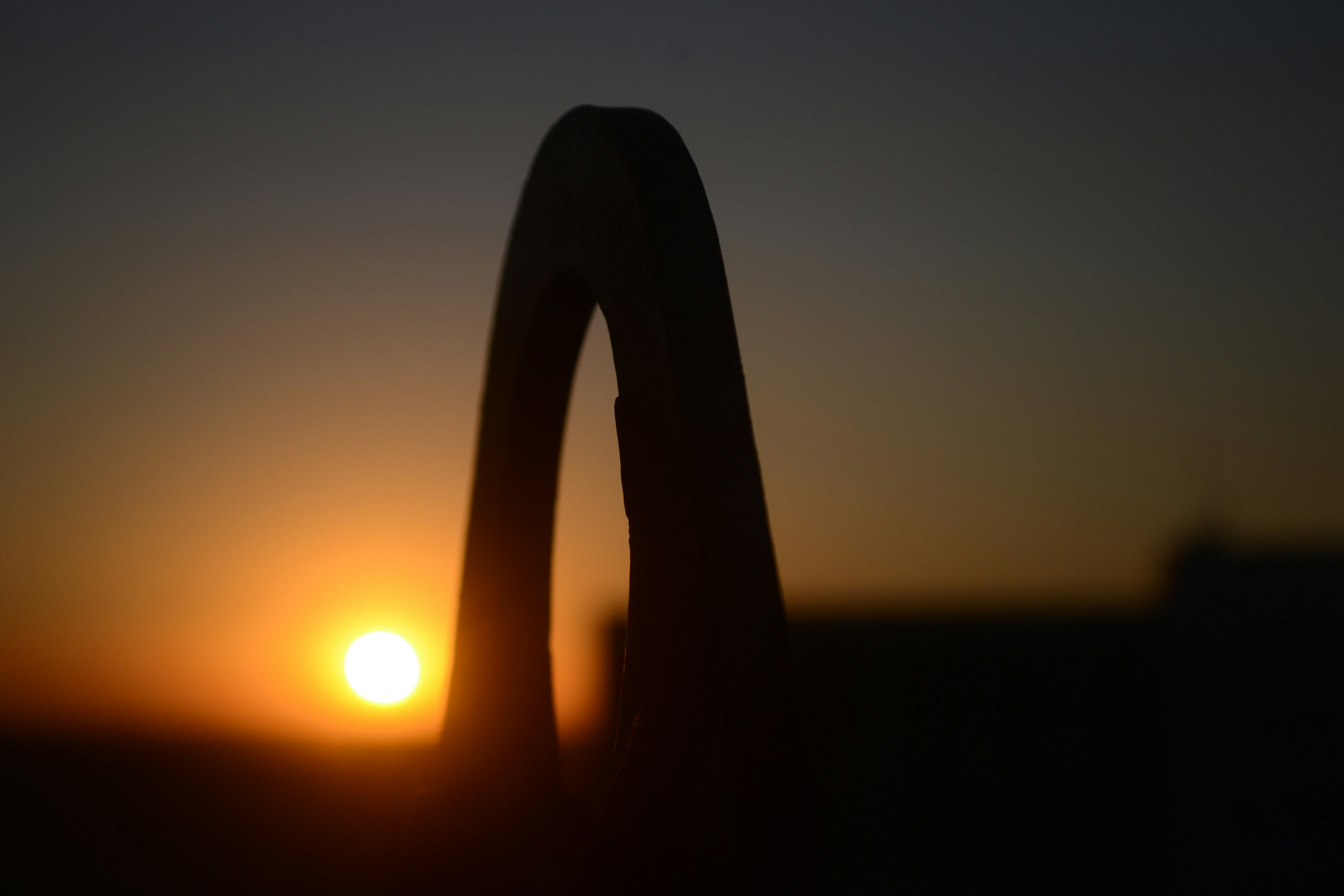 Sun Through the Arch: A Dusk Silhouette Framing the Horizon