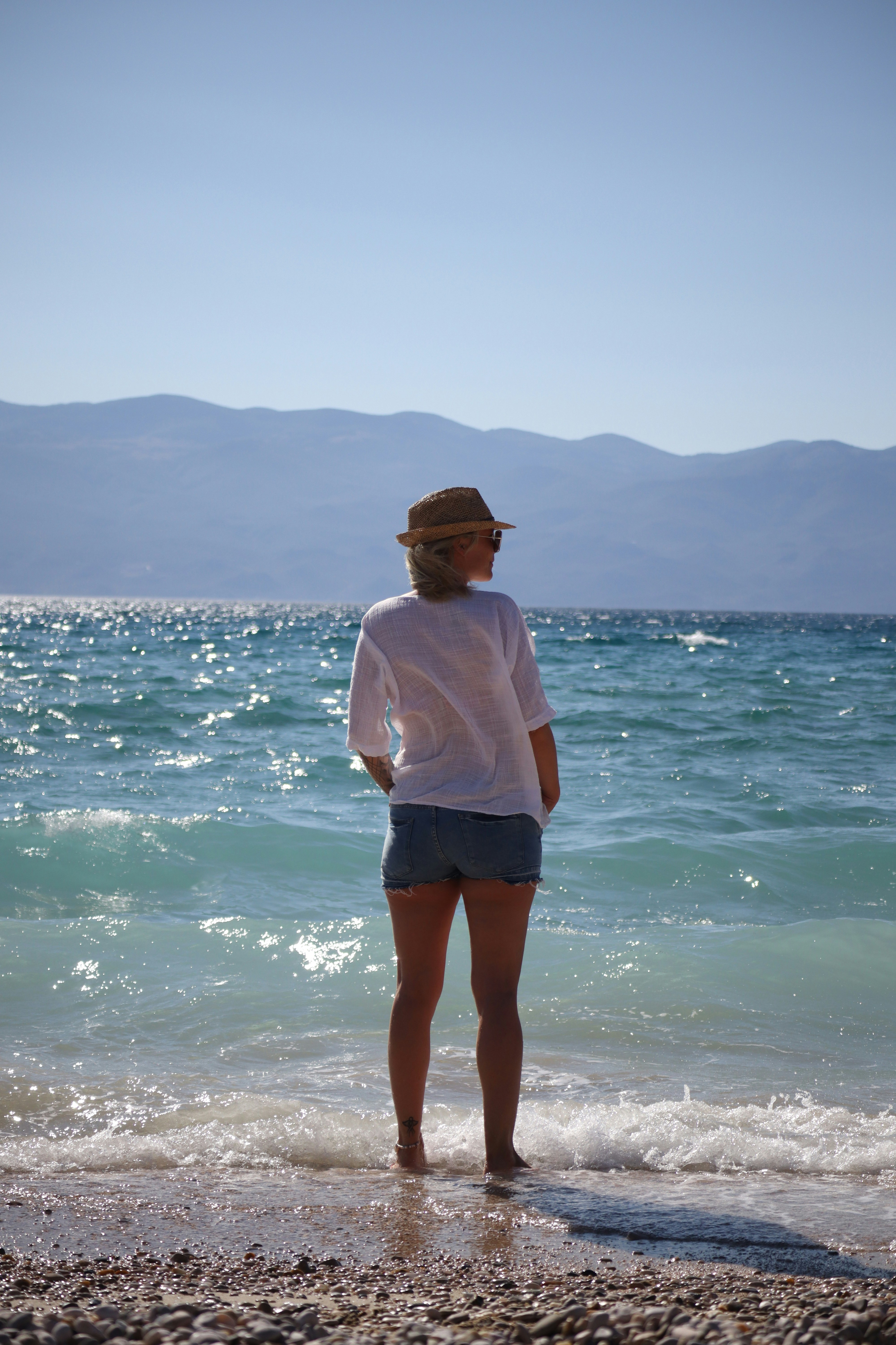 Solitary by the Sea: A Wanderer Faces the Mountain Horizon