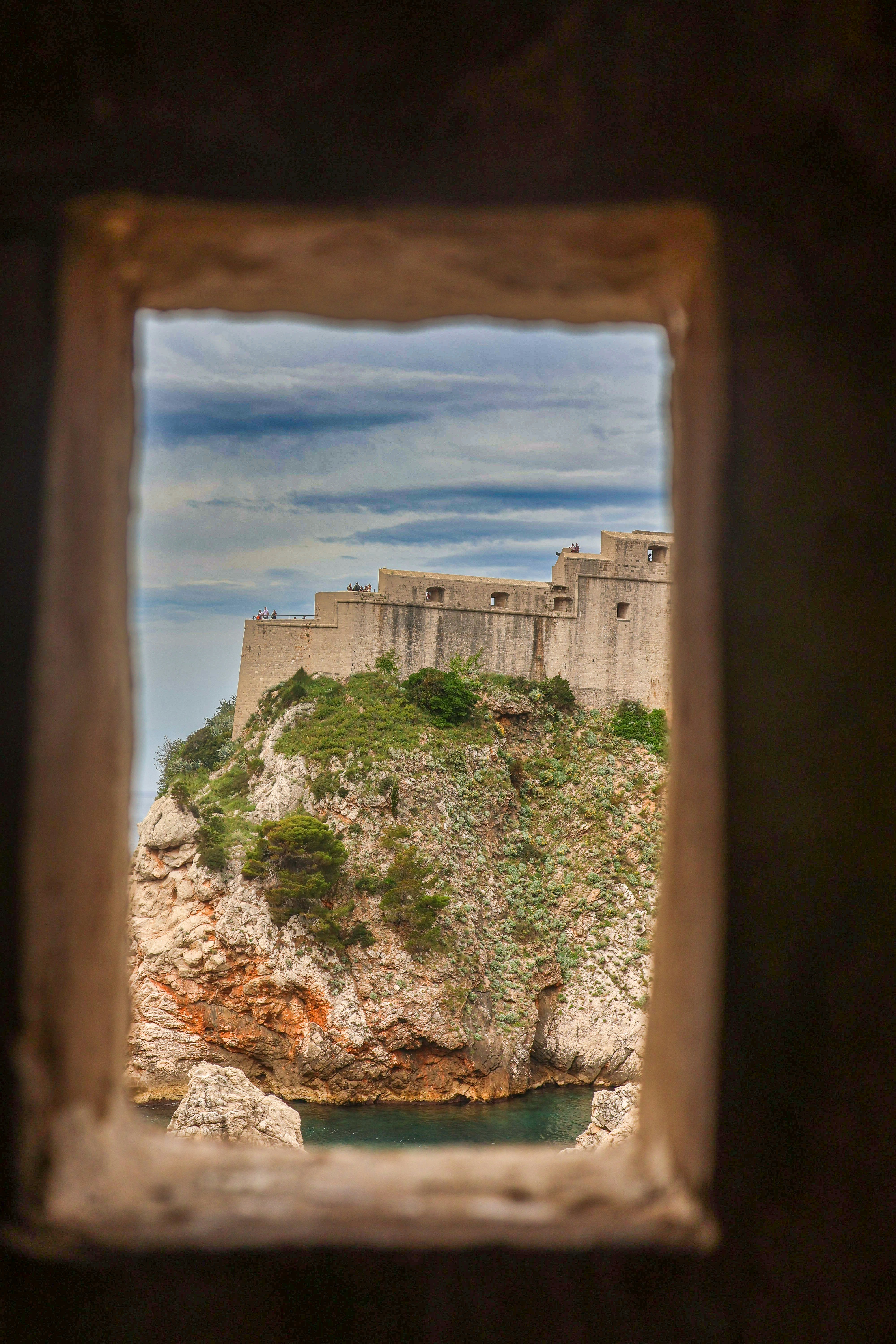 Cliffside Fortress Framed by a Weathered Window