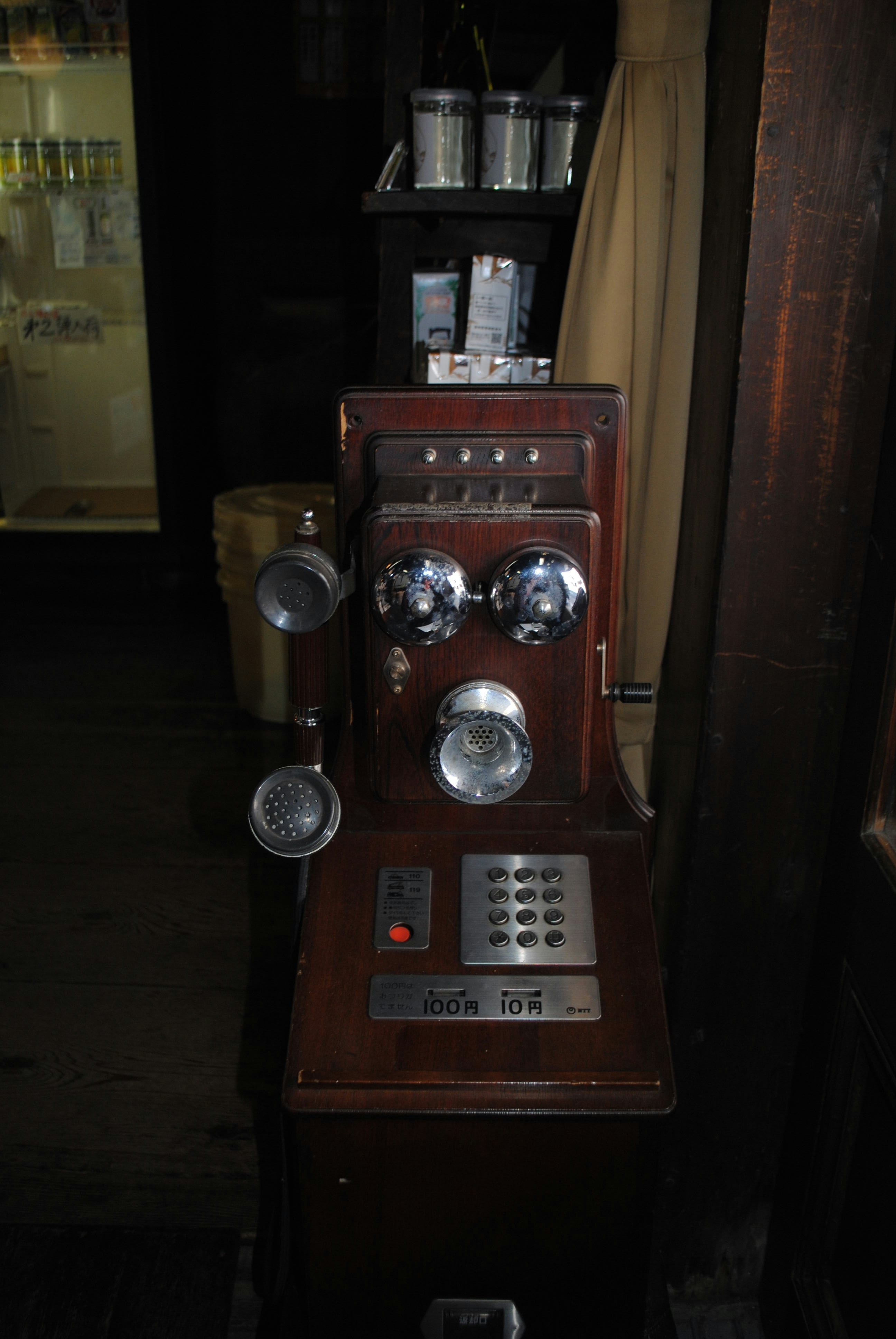 Whispers in Wood and Chrome: A Vintage Payphone Stands in Twilight