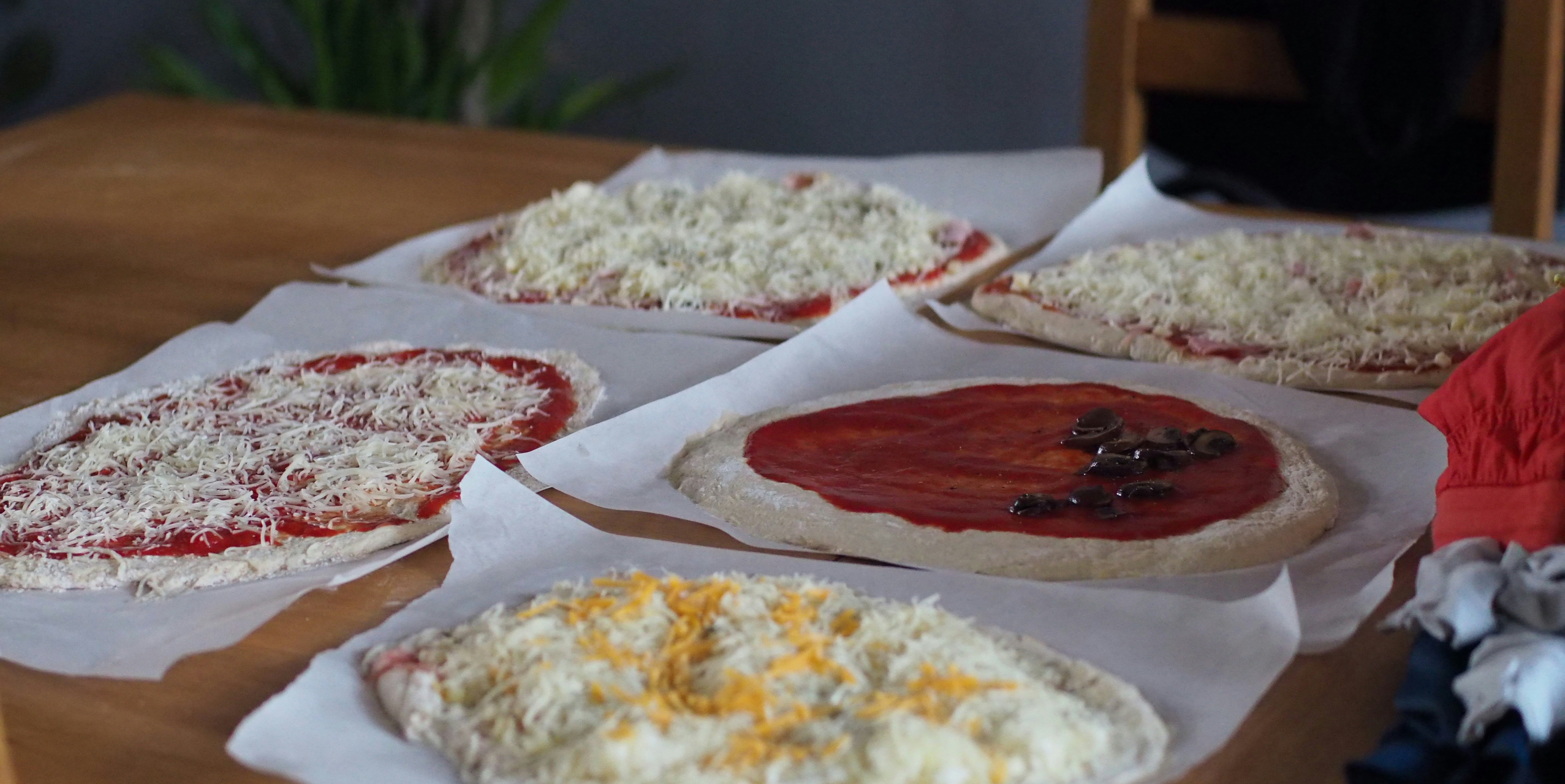 A table topped with pizzas covered in cheese and toppings photo – Free ...