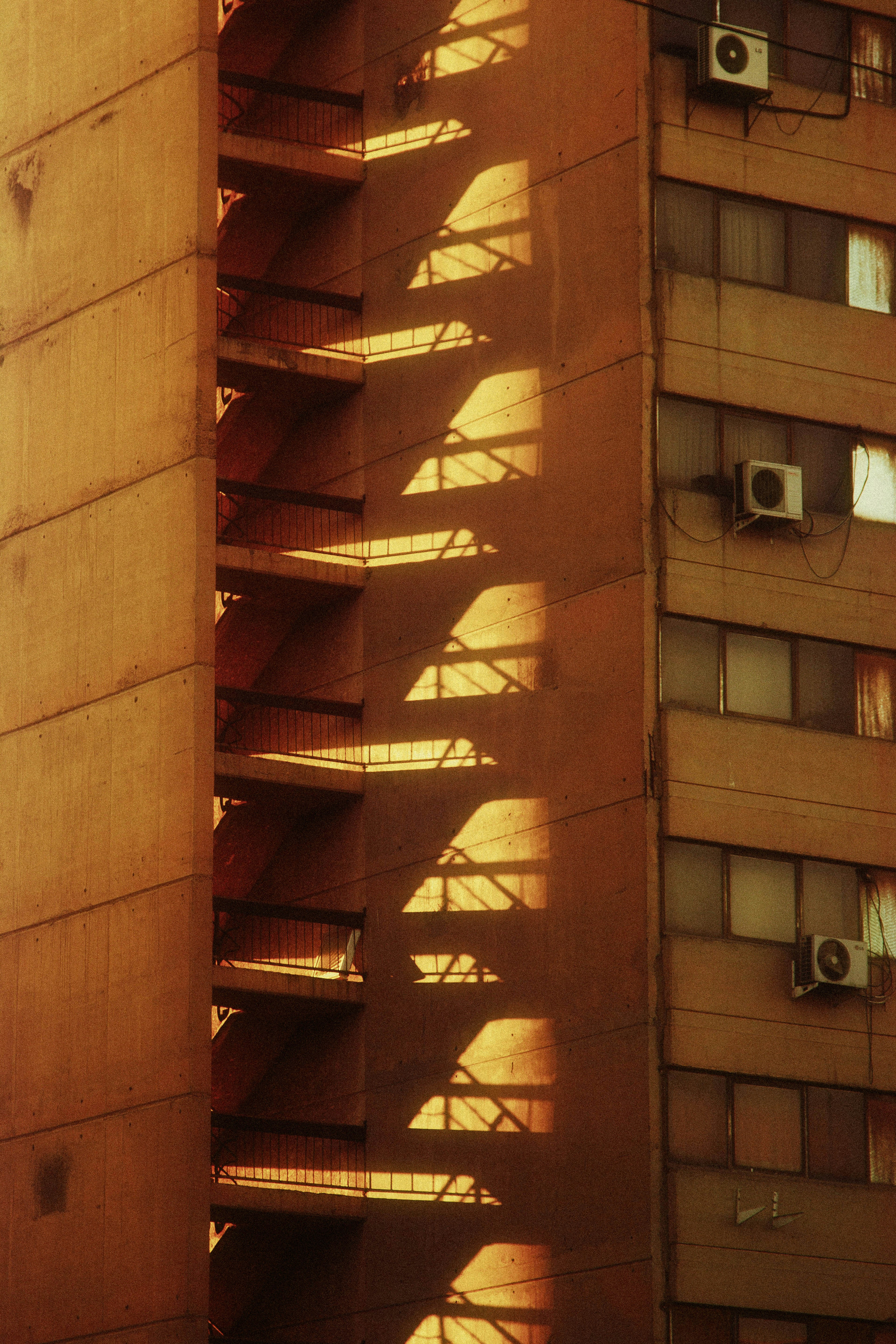 Sunlit Geometry: Shadowplay of Fire Escapes on a Brick Facade
