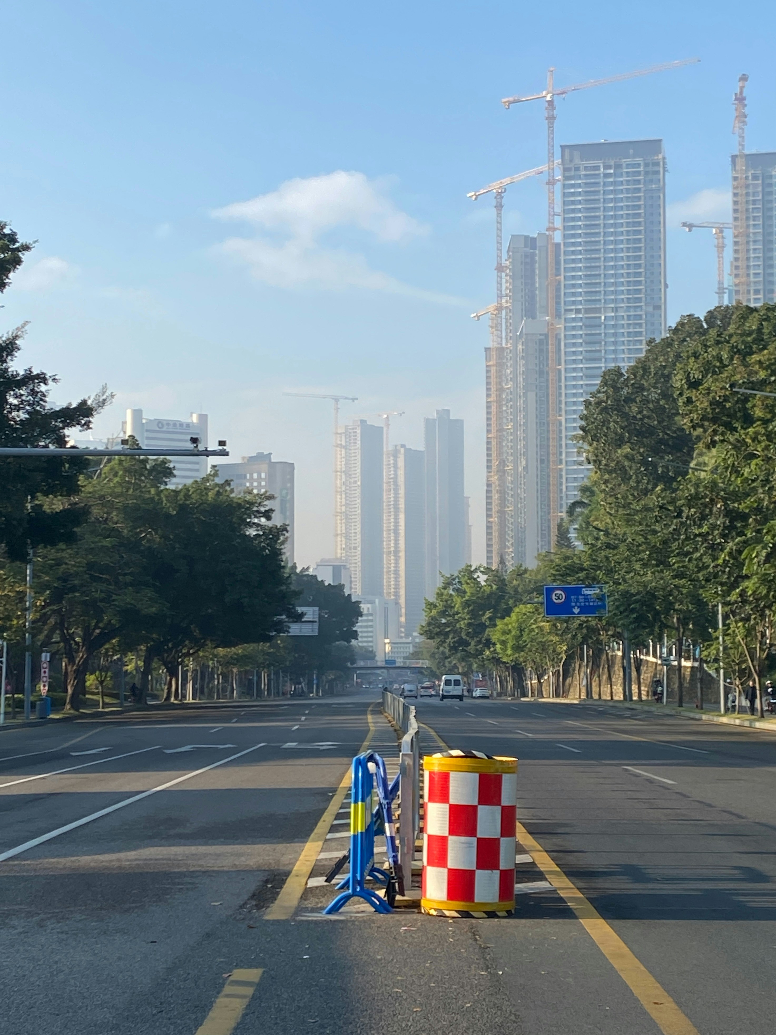 Blue-Sky Boulevard: Cranes Frame a Growing Skyline