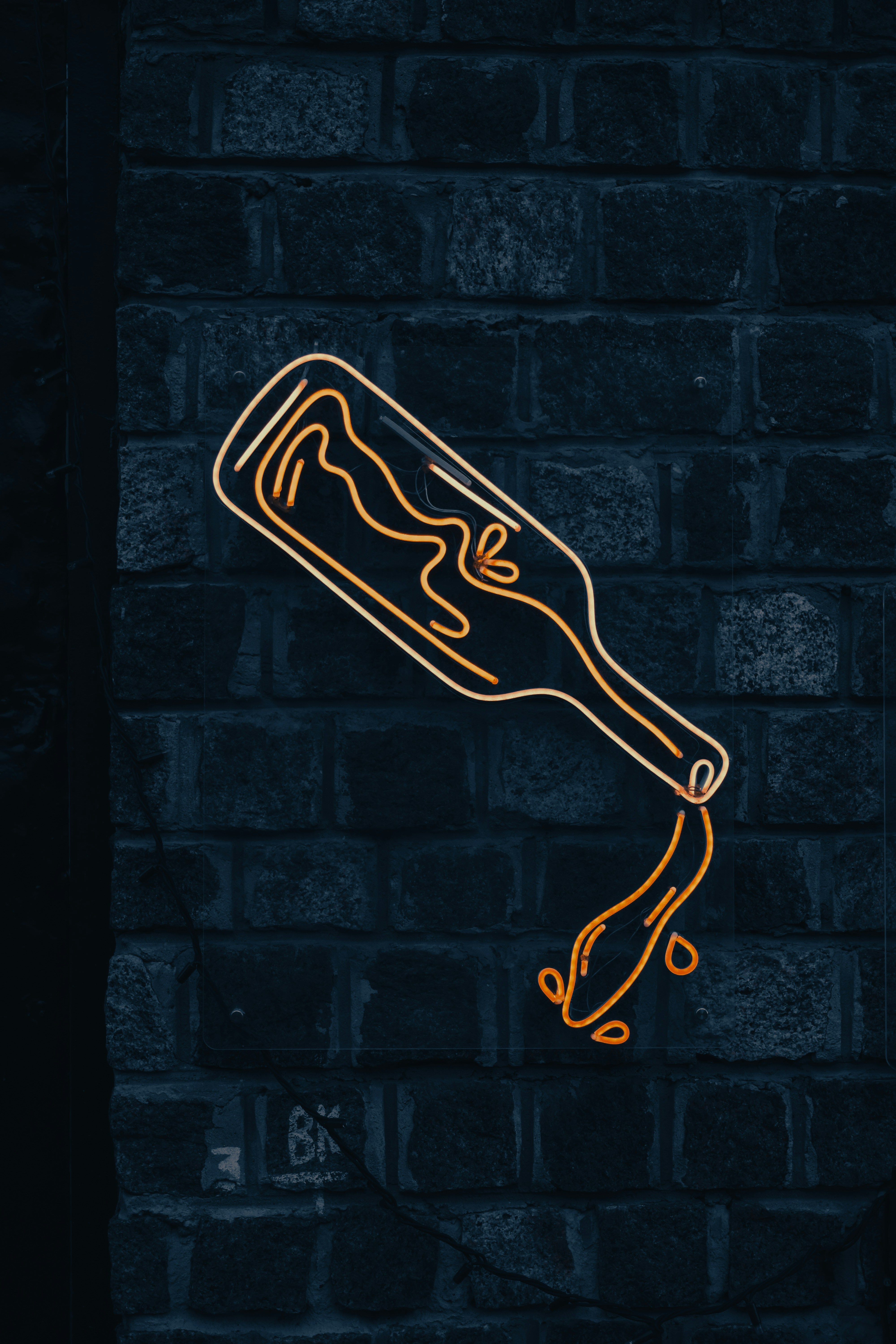 Neon Bottle Pour: A Glowing Outline on a Brick Wall