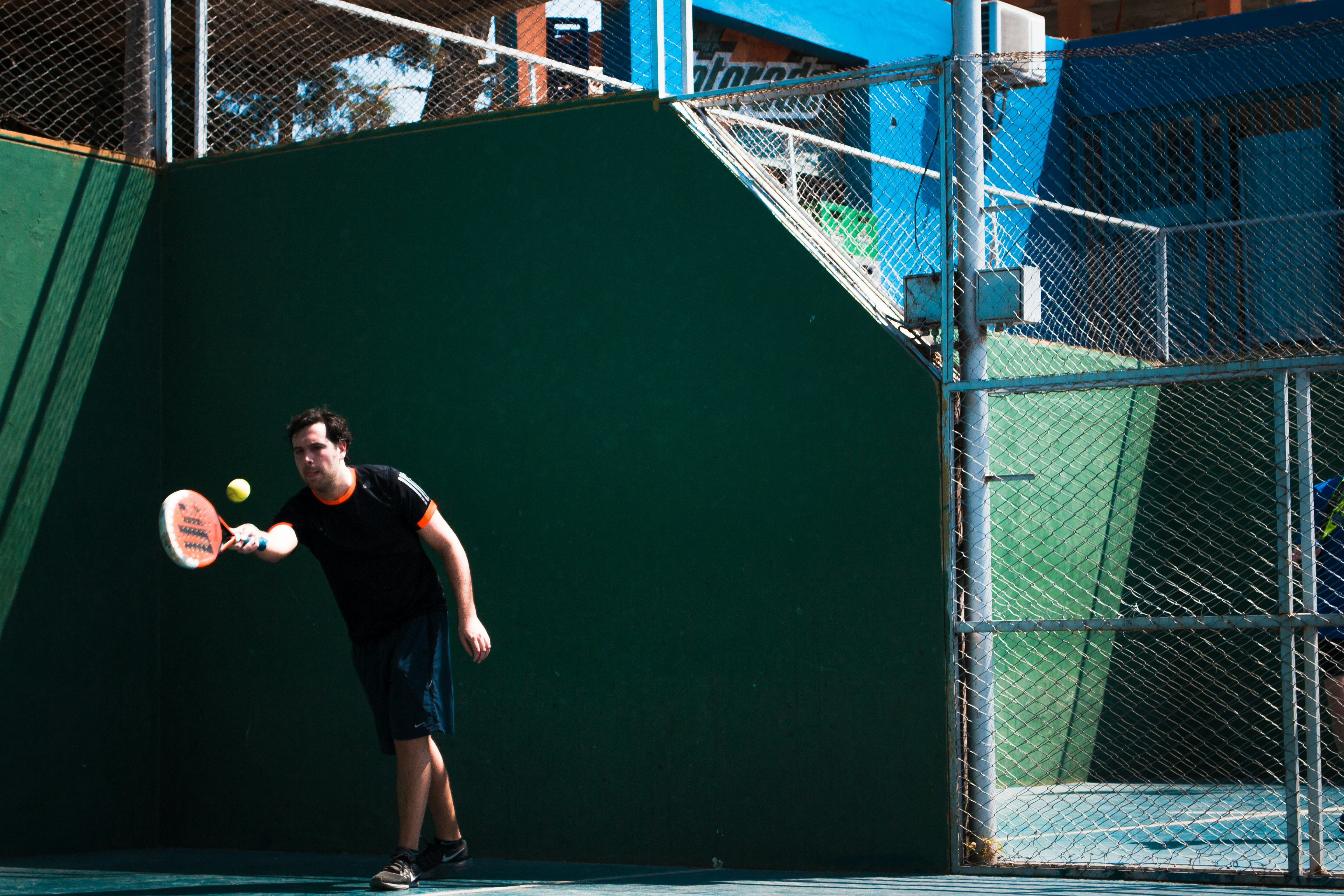 A man swinging a tennis racquet at a tennis ball photo – Free Woman ...