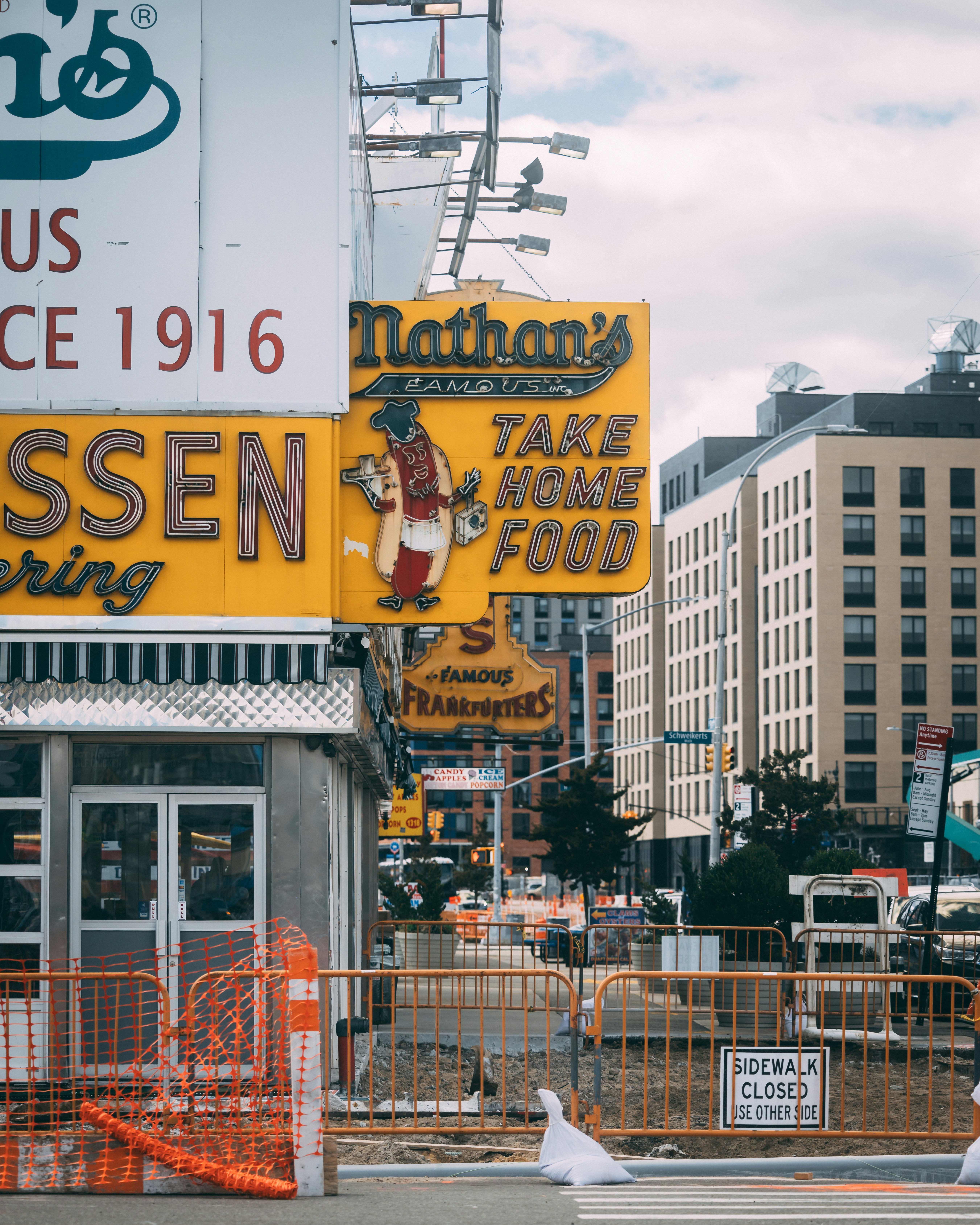 A large yellow sign hanging from the side of a building photo – Free ...