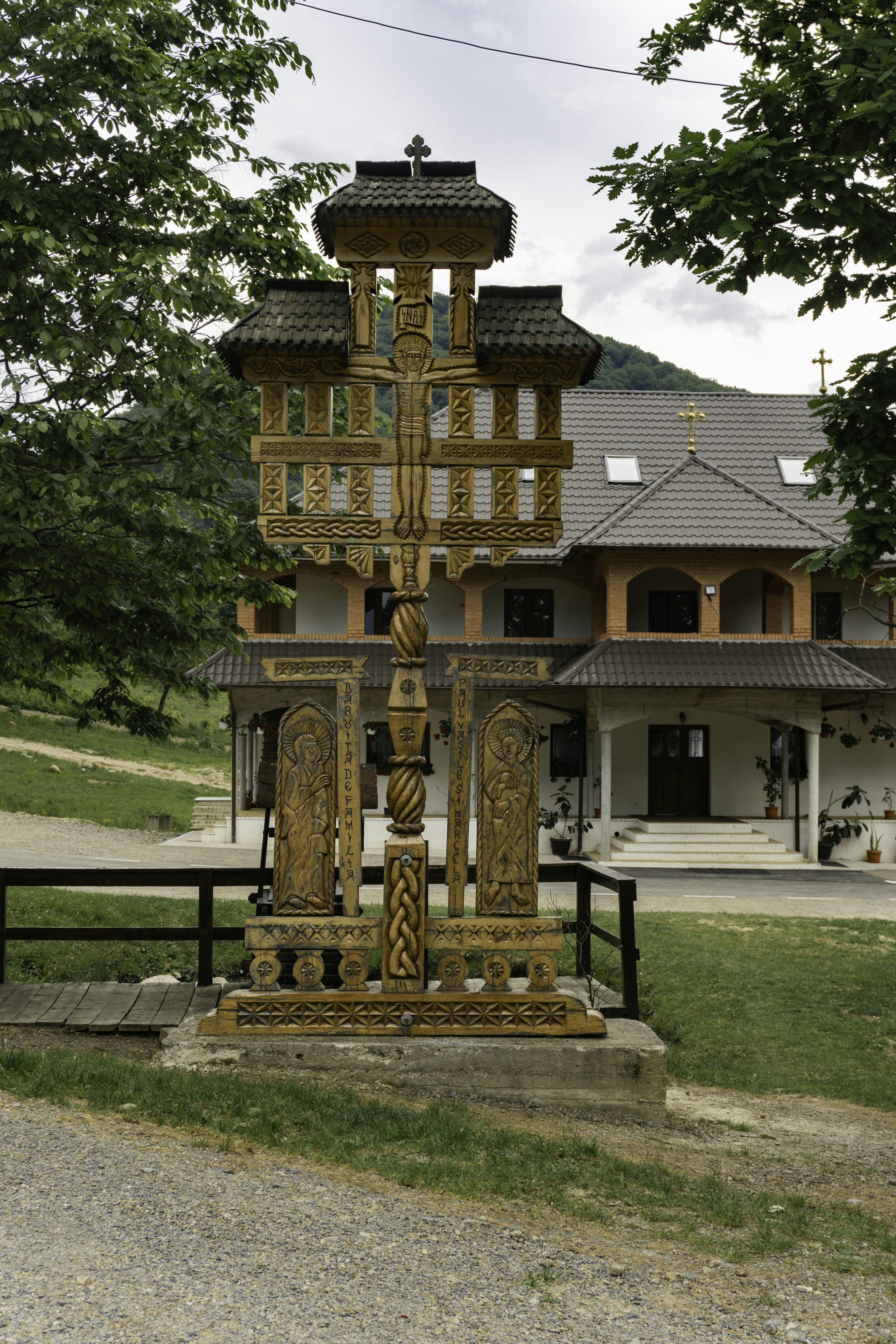 Ornate Timber Cross Sculpture Guarding a hillside church courtyard
