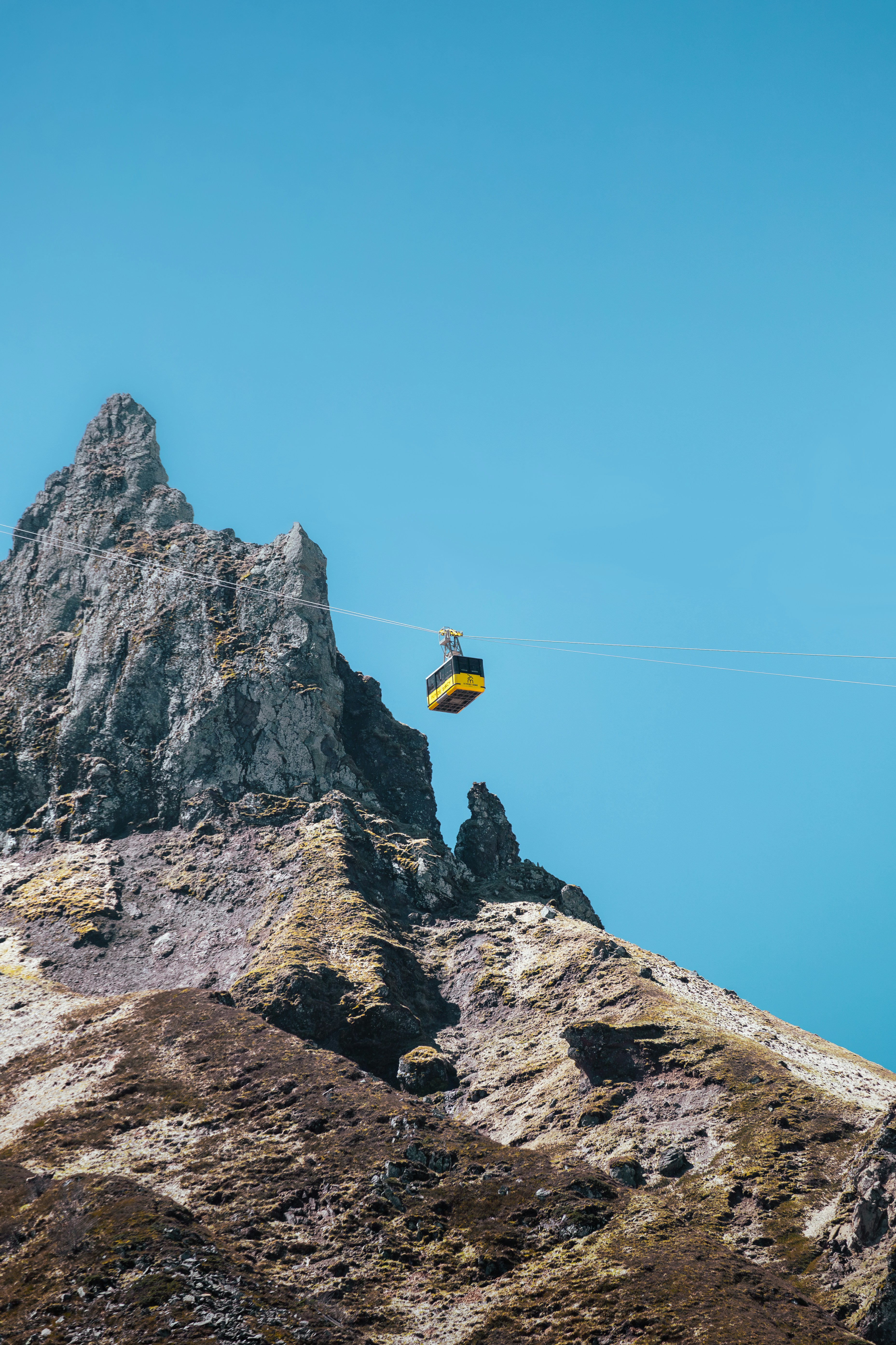 Yellow Gondola Above Rugged Peaks